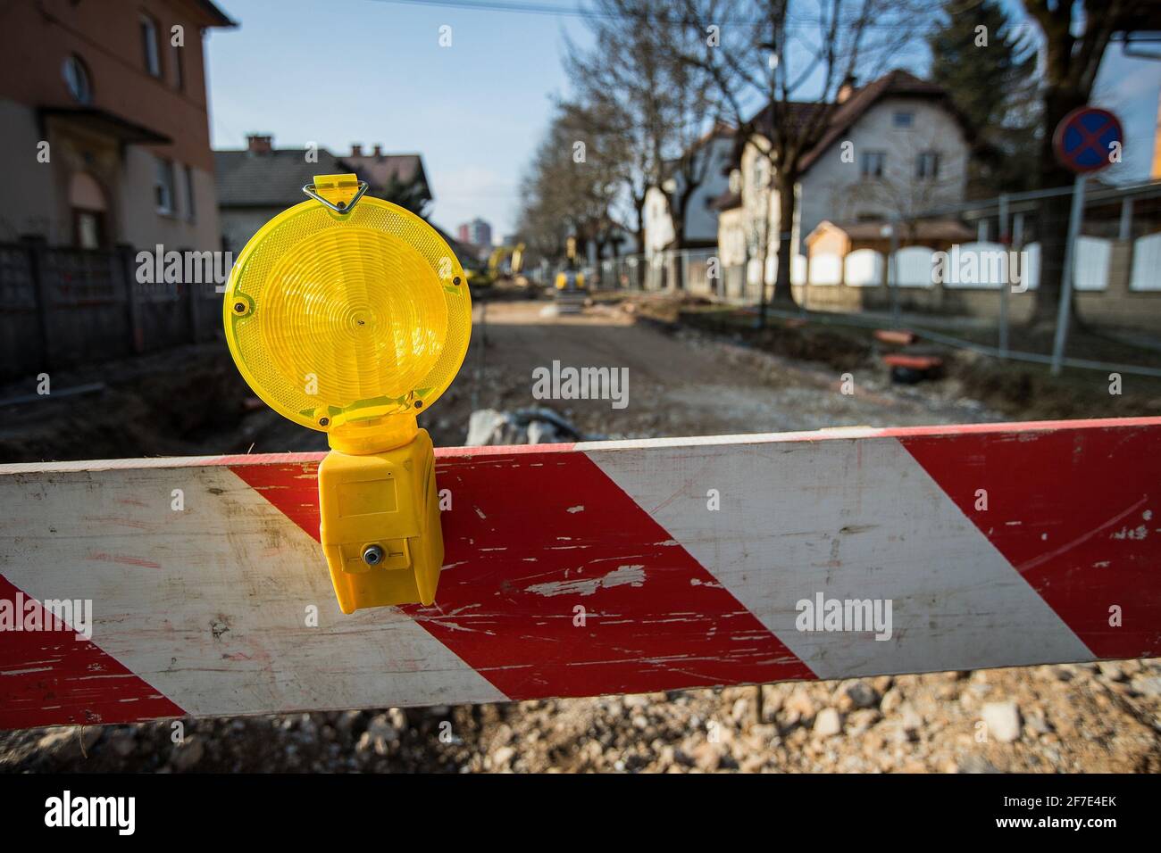 Yellow barrier light or lantern is mounted on a red and white road ...