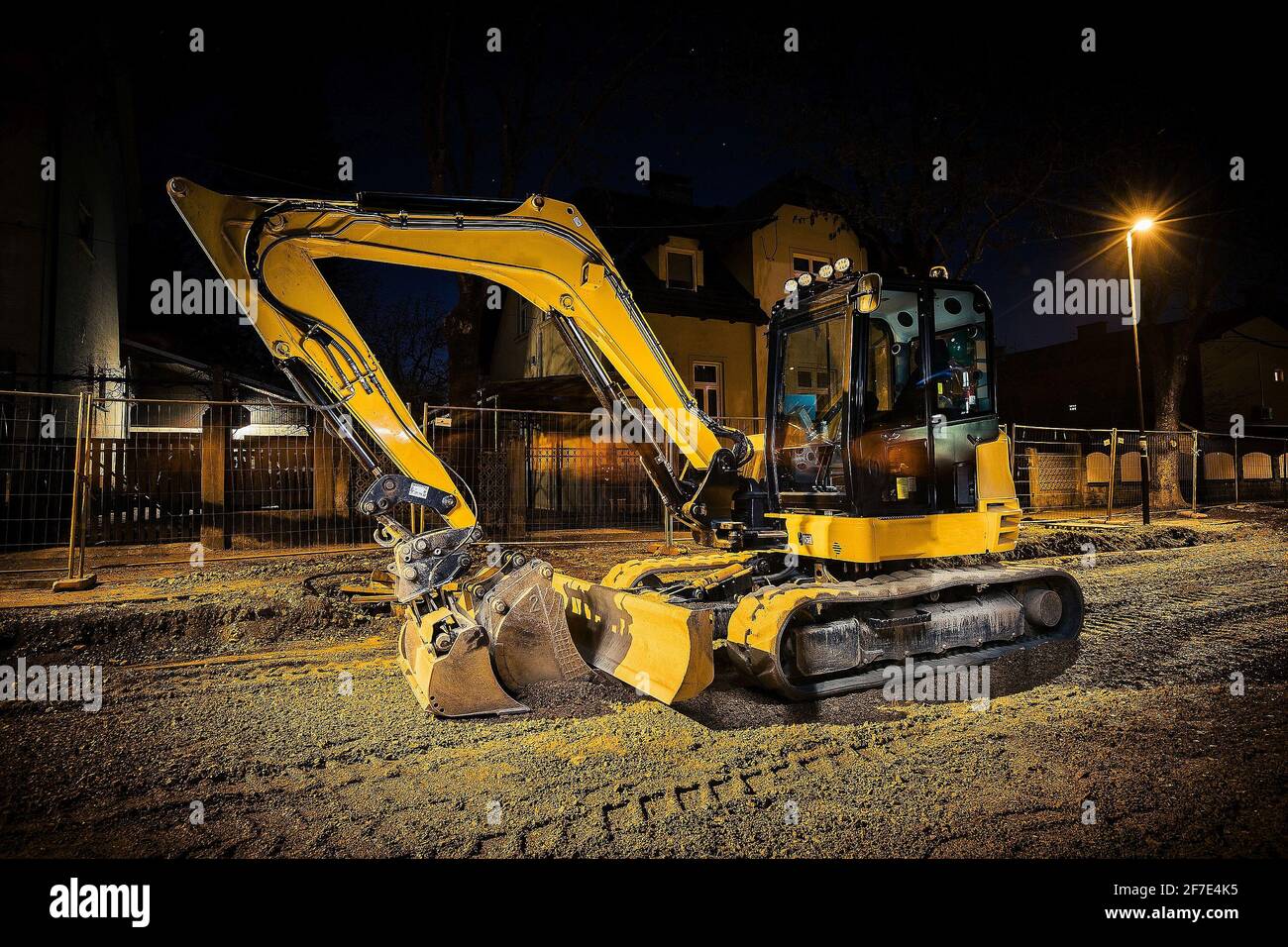 Construction site on a city street. A yellow digger excavator parked ...