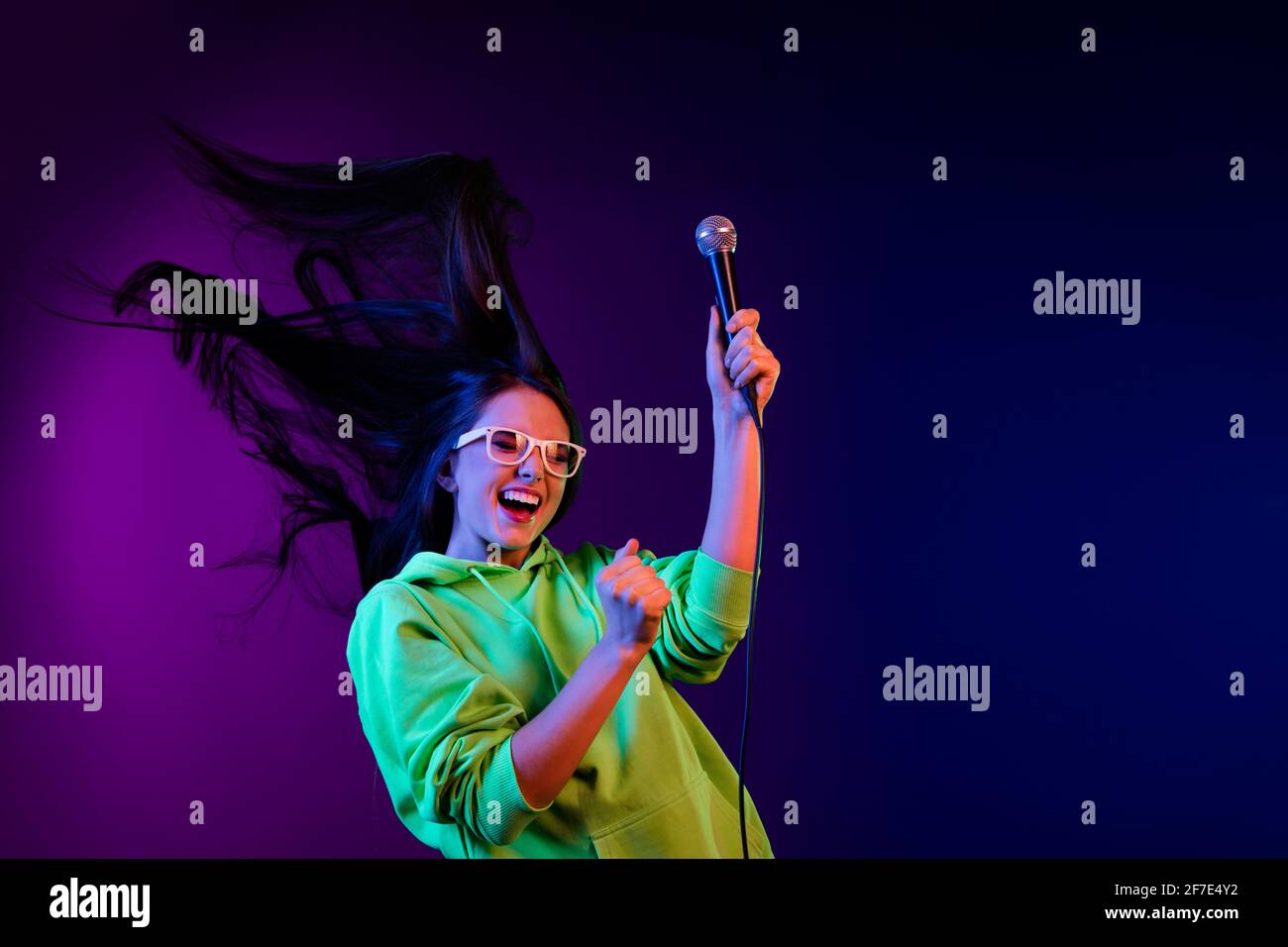 Photo of cheerful crazy funky young woman raise microphone fly hair ...