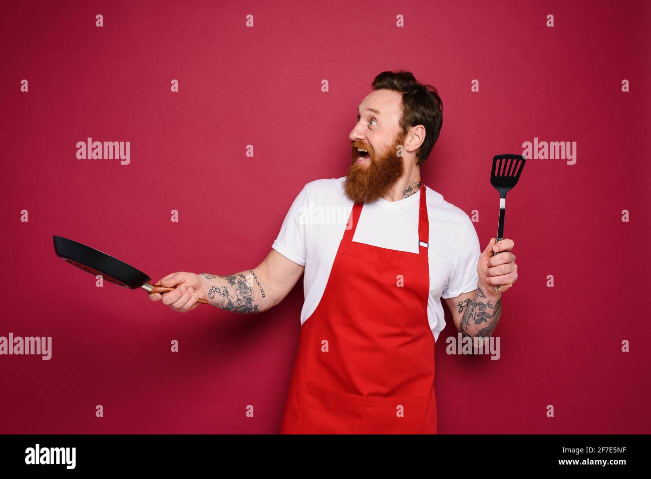Happy chef cooks a new creative recipe. red background Stock Photo - Alamy