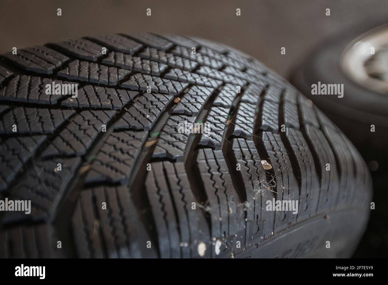 Old winter tire but still with plenty of tread. some stones are seen ...