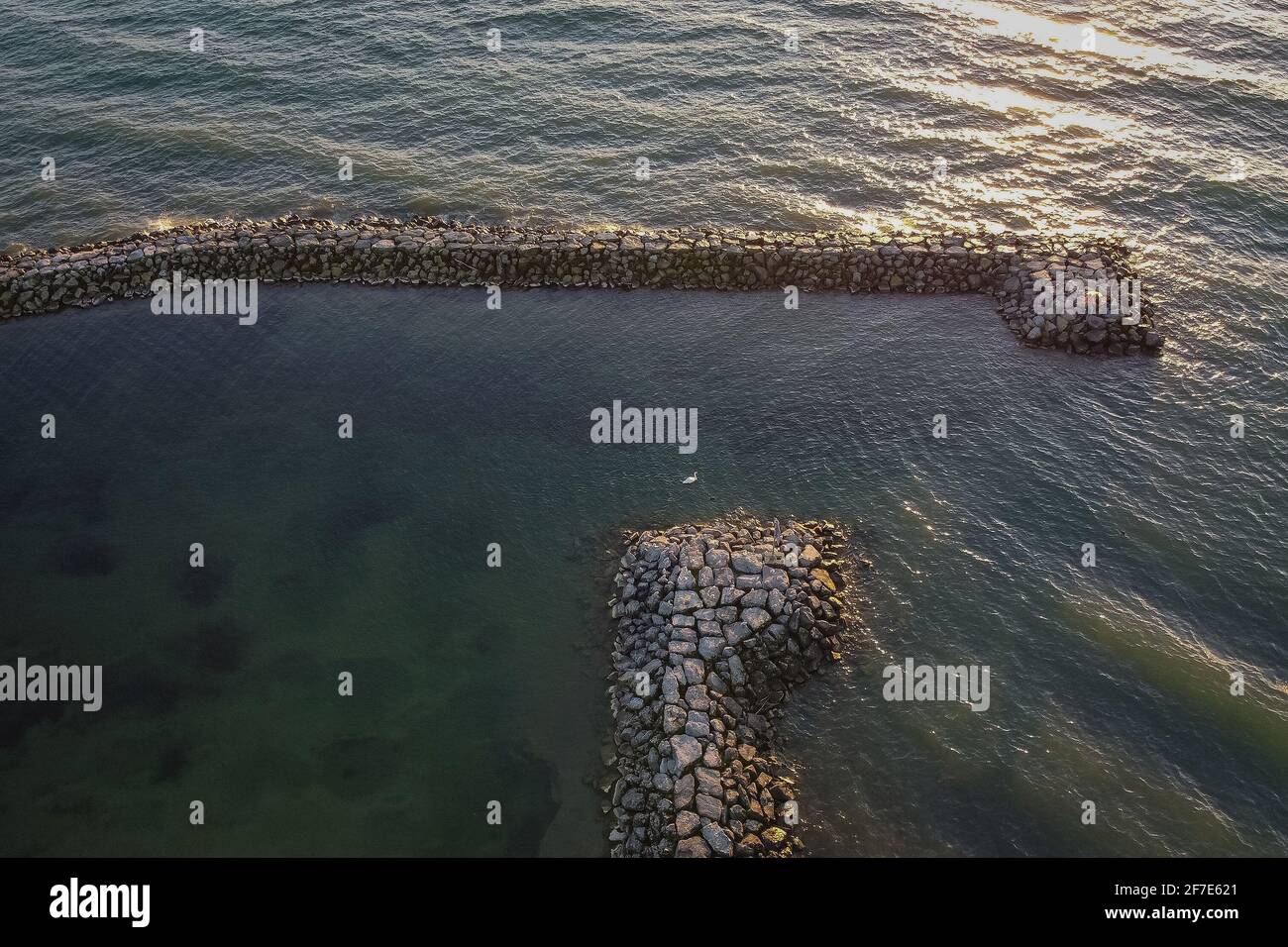 Tidal barrier around a small marina. Breakwater barrier made of stones ...
