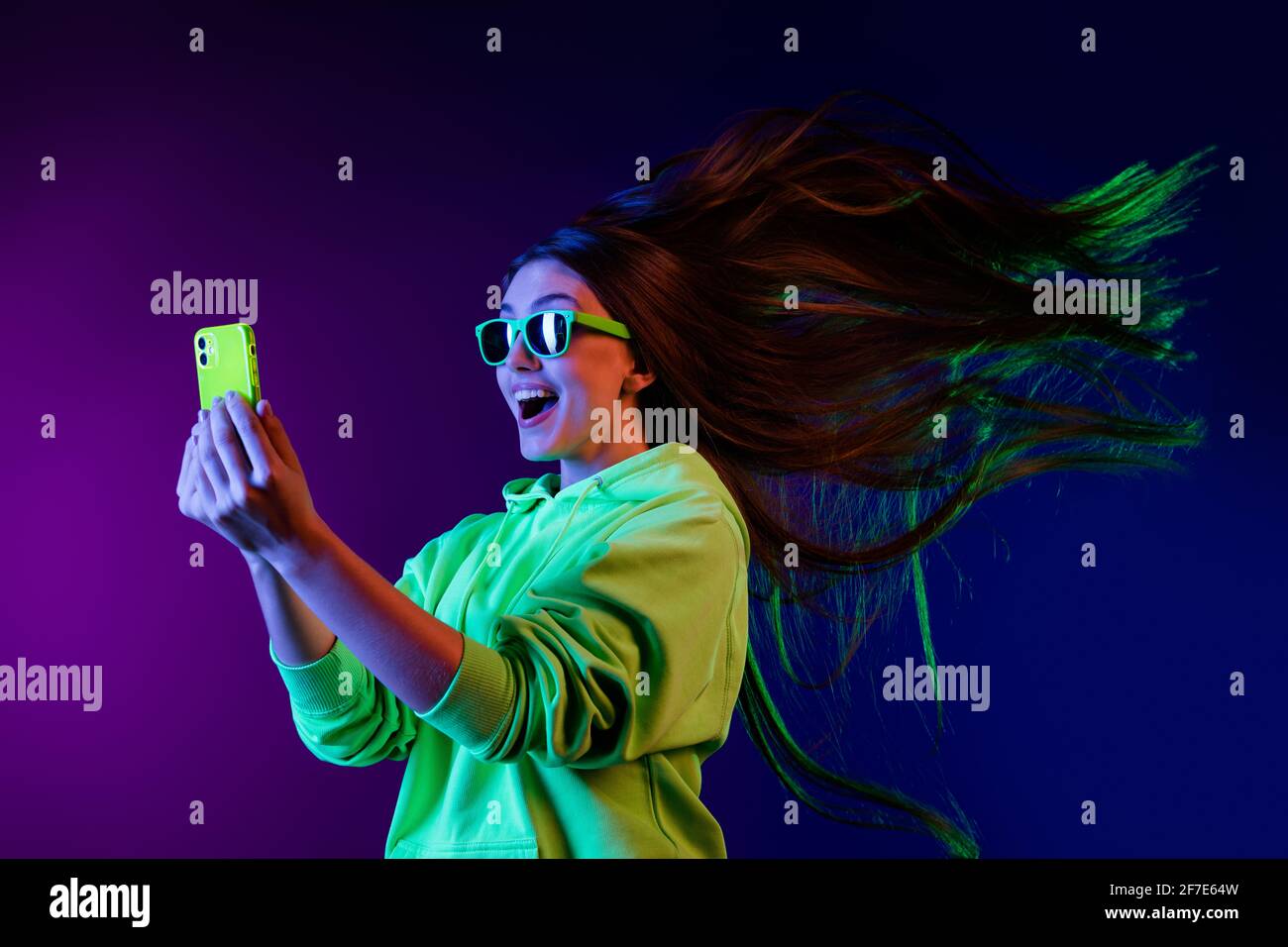 Photo of amazed shocked young woman look phone fast internet fly hair ...