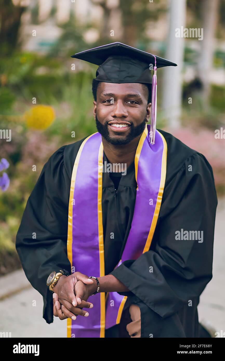 Young man graduating college, wearing a graduation gown/cap Stock Photo ...