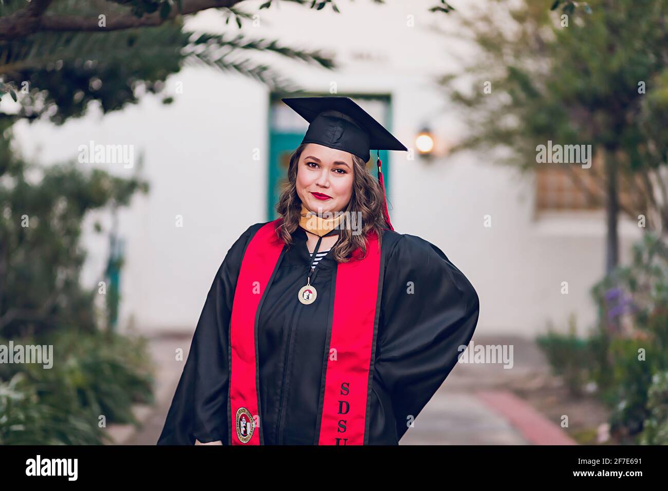 Female millennial graduating college, wearing a graduation gown/cap ...