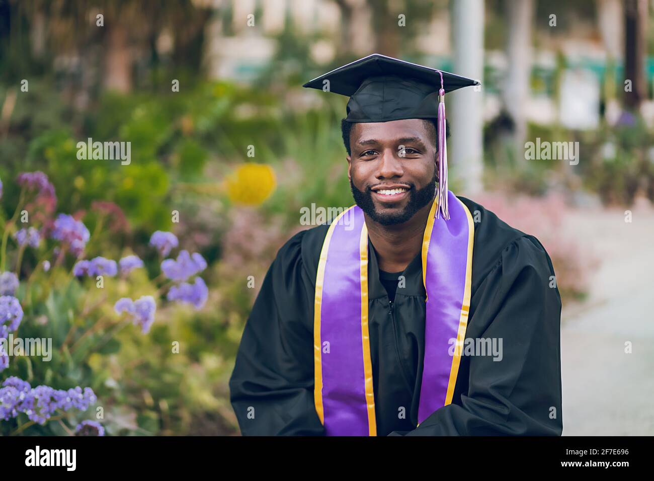 Young man graduating college, wearing a graduation gown/cap Stock Photo ...