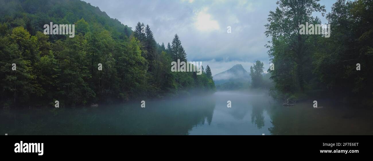 Scary spooky river of Kolpa on a gray dull summer day with clouds and ...
