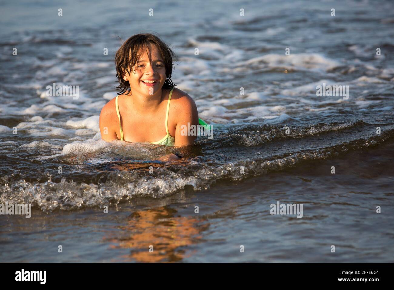 Eleven Year Old Girl Boogie Boarding And Smiling In Ocean On Cape Cod