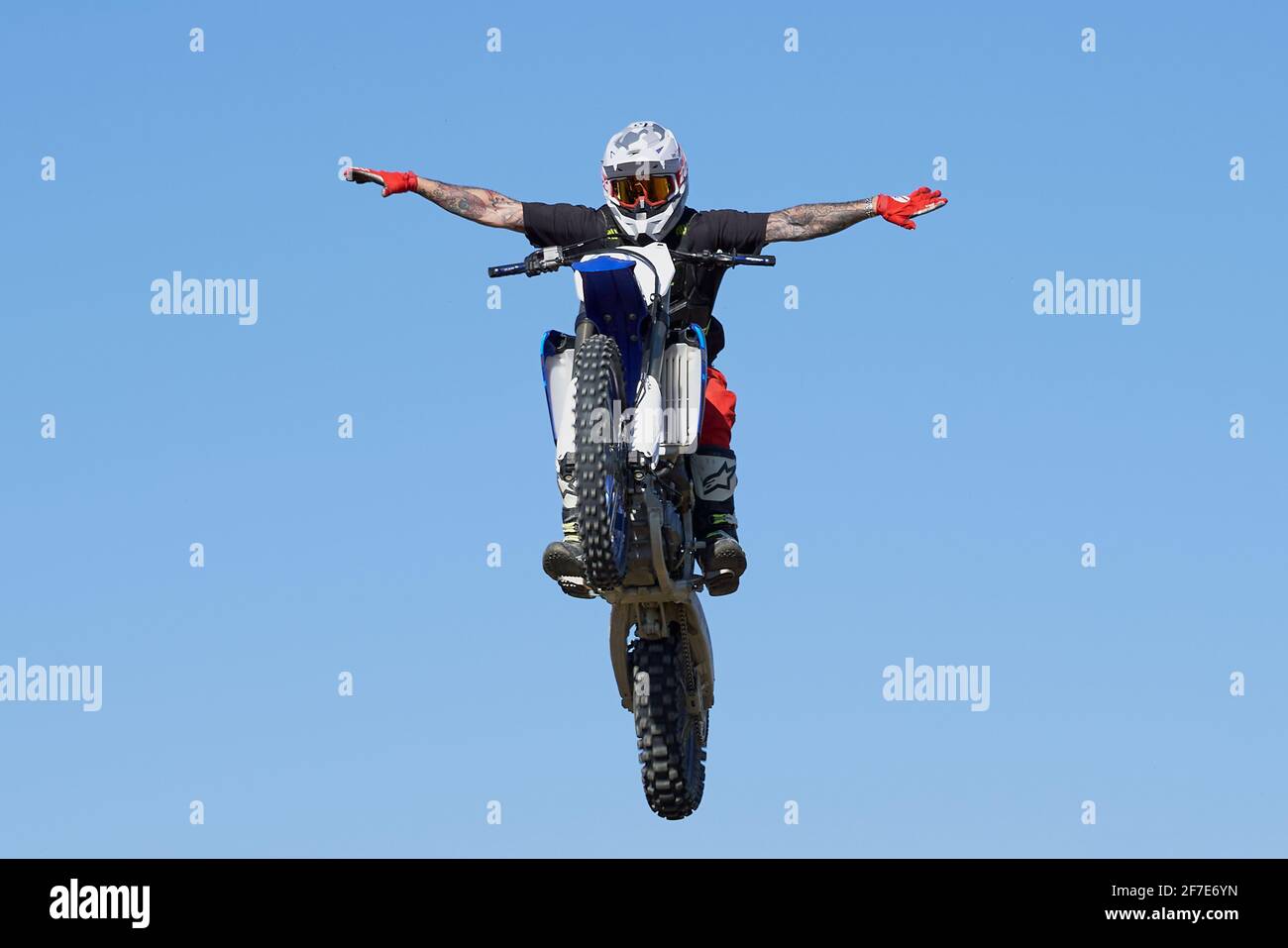 Side view of man performing stunt with motorcycle on motocross t Stock ...