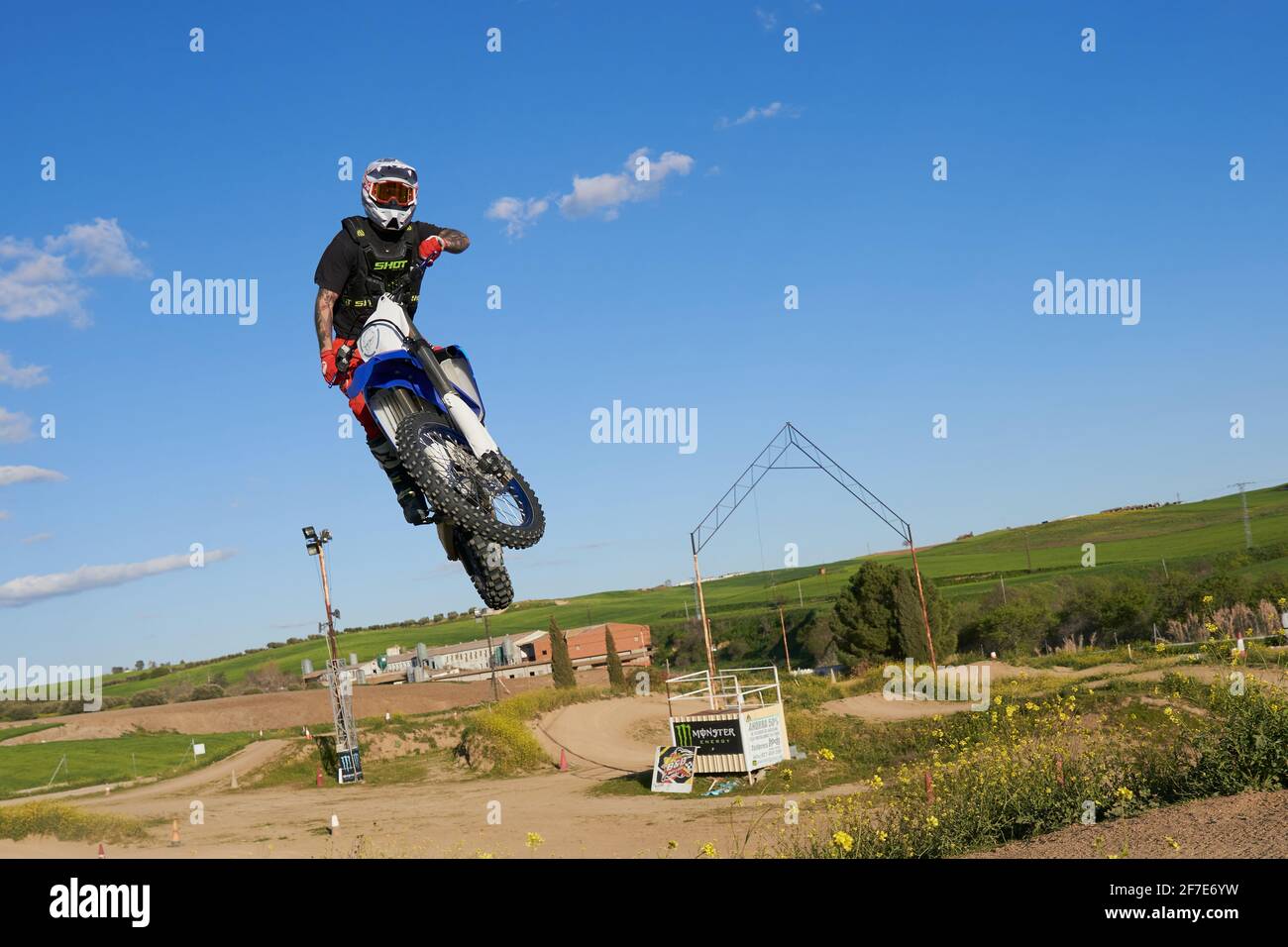 Side view of man performing stunt with motorcycle on motocross t Stock ...