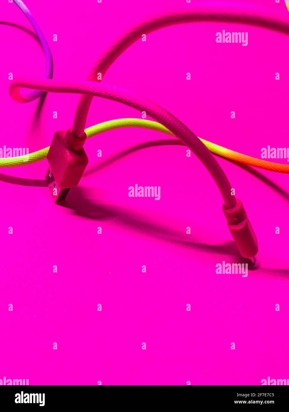 pink neon rainbow tech usb cord on hot pink background vertical layout ...