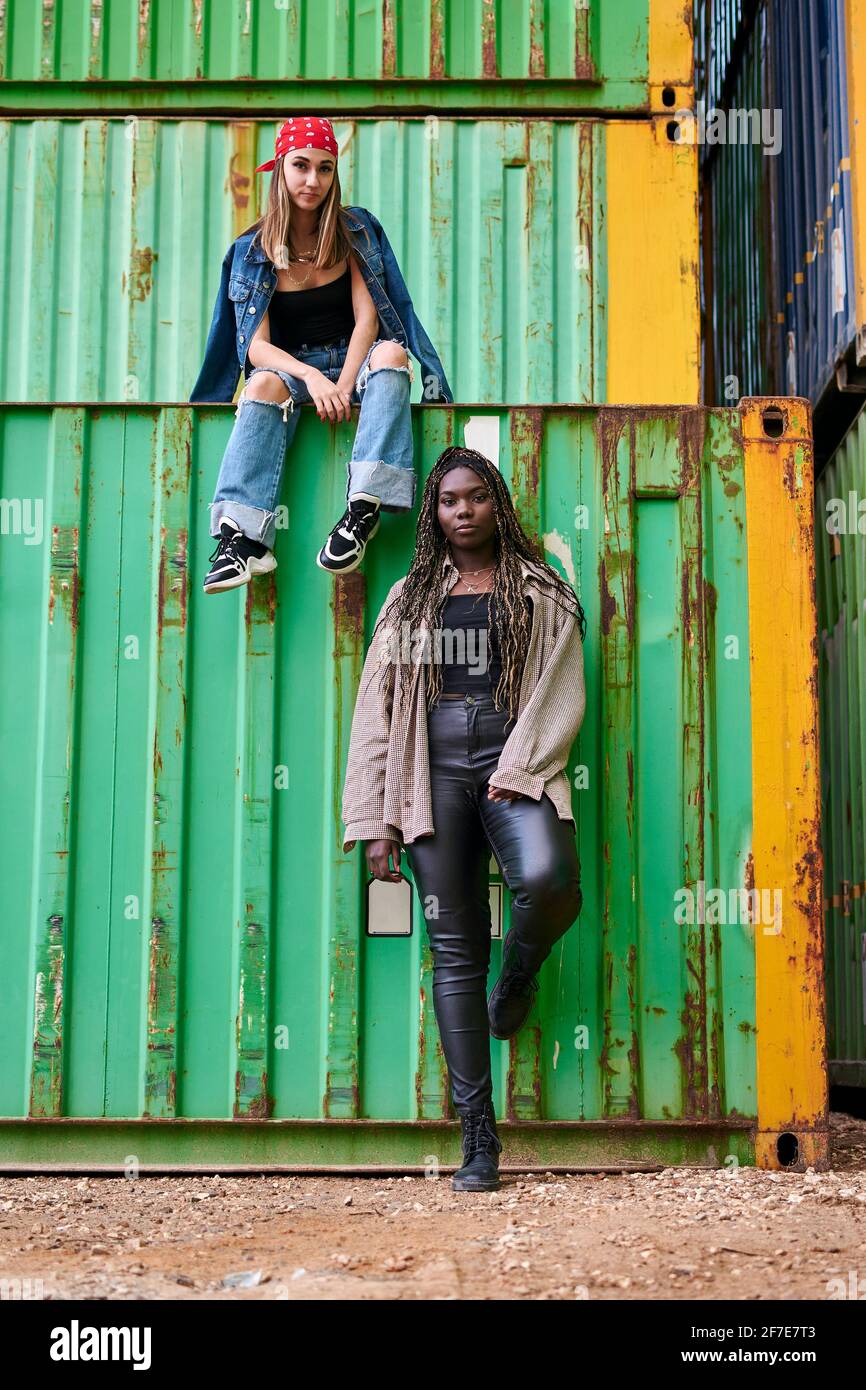 Two multiethnic women pose surrounded by shipping containers Stock ...