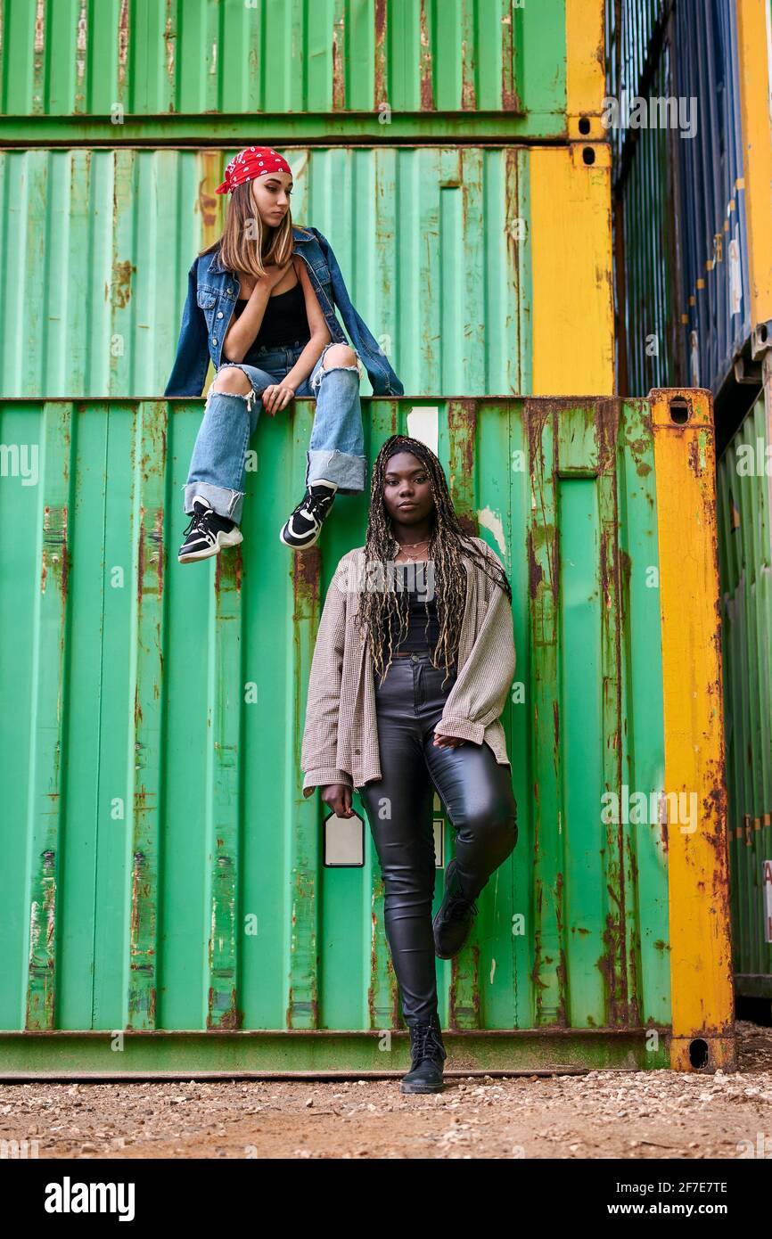 Two multiethnic women pose surrounded by shipping containers Stock ...