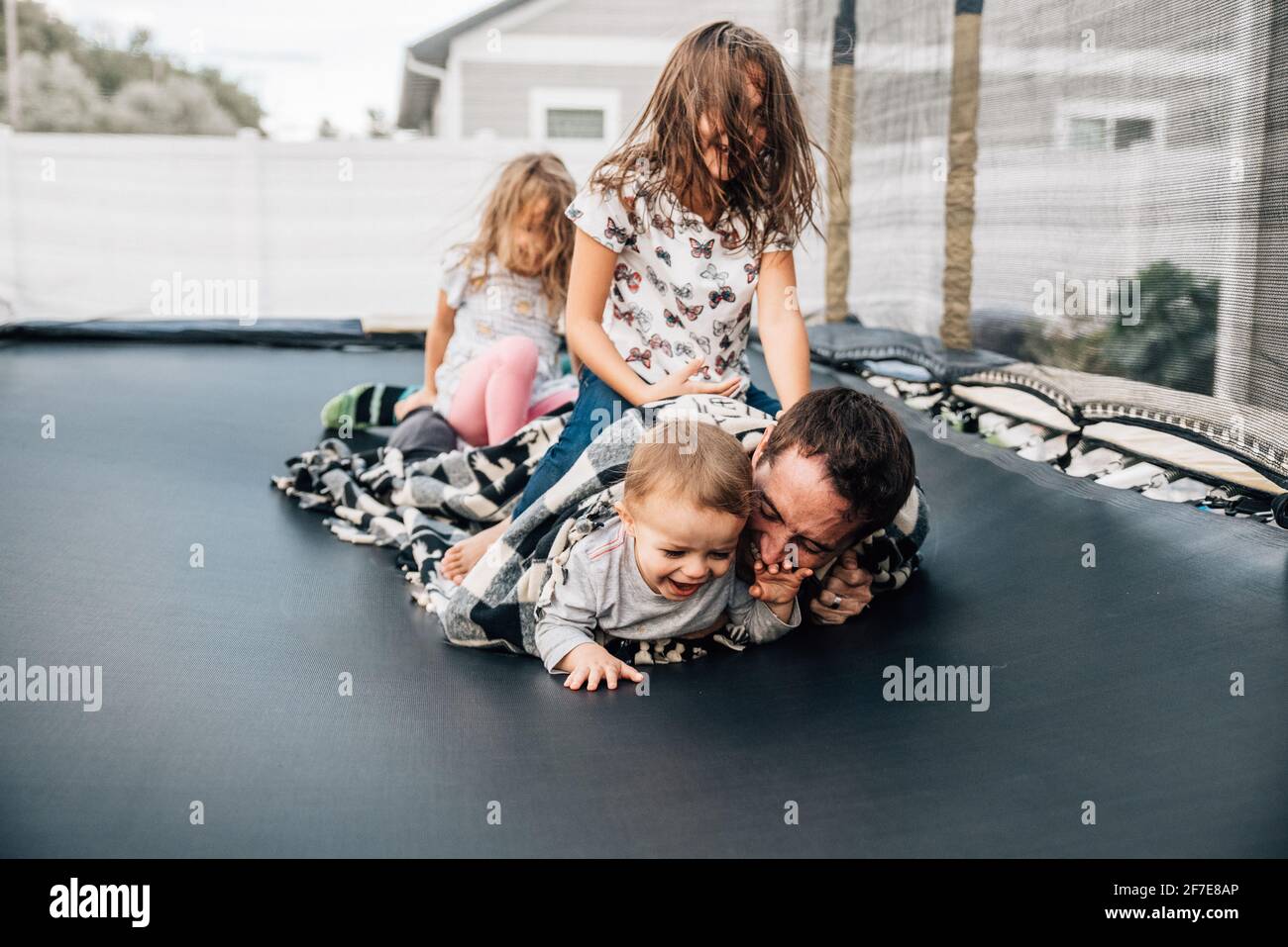 Family jumping on a trampoline in the backyard Stock Photo - Alamy