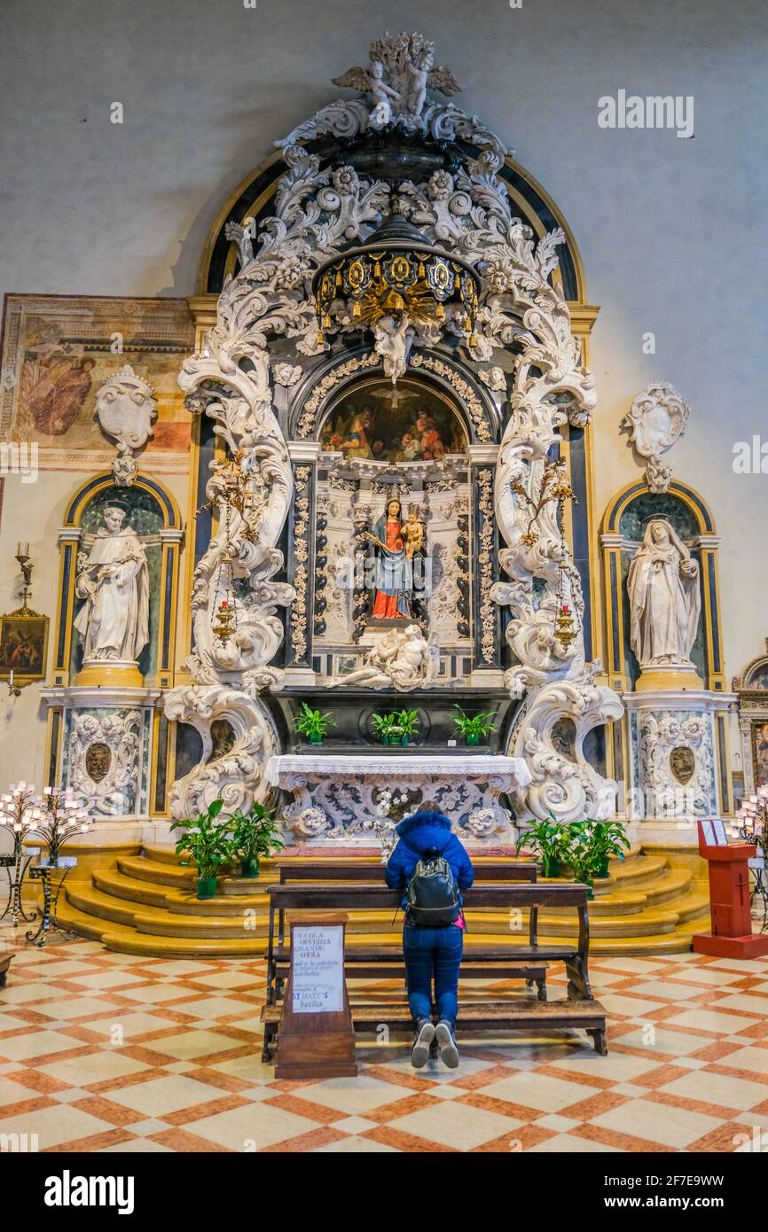 A woman praying in Chiesa di Santa Maria dei Servi in Padua Italy Stock ...