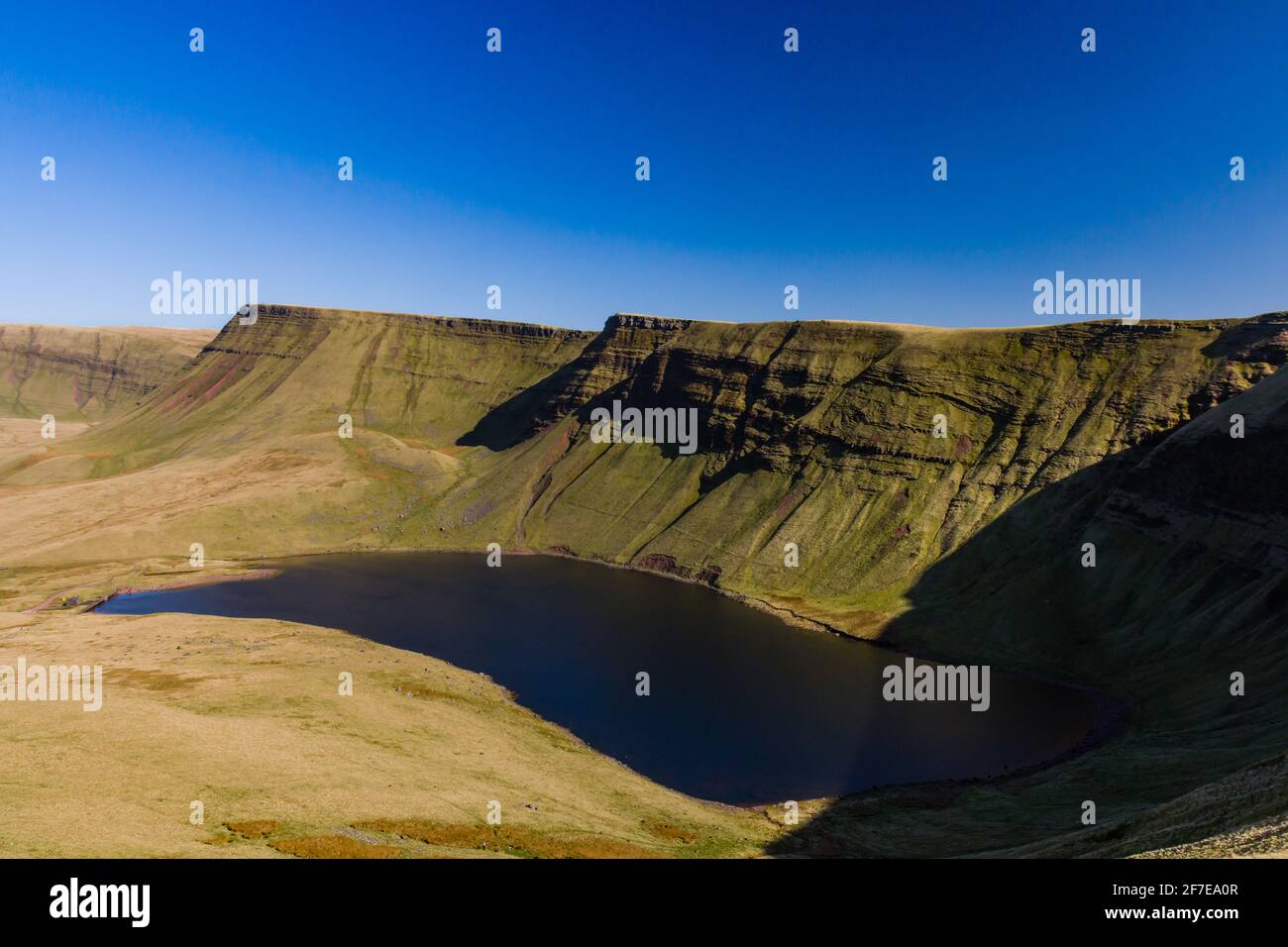 A beautiful lake at the foot of steep-sided mountains (Llyn y Fan Fach ...