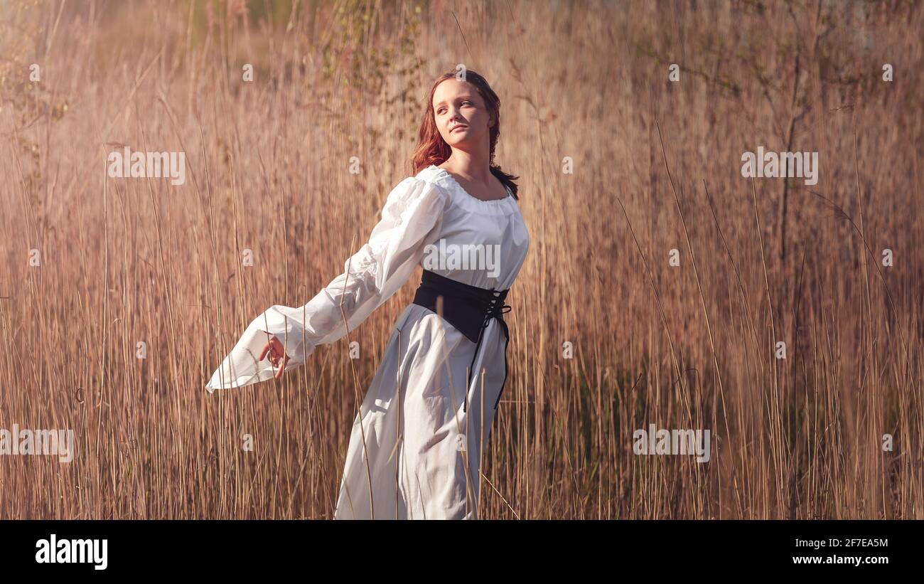 Medieval young woman in historical female costume at nature. Fantasy ...