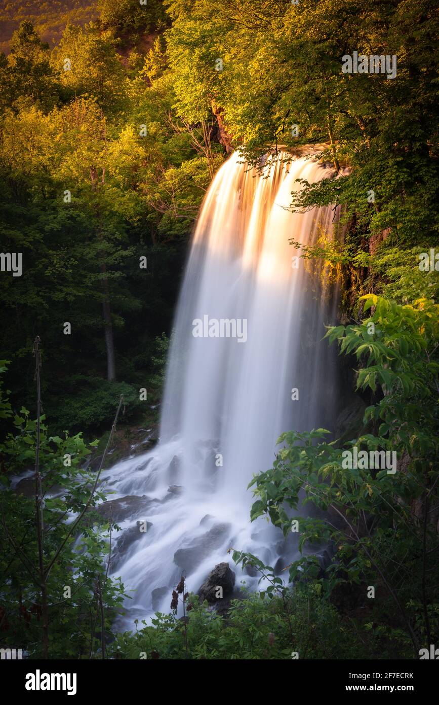 Light from the setting sun illuminates the top of Falling Spring Falls ...