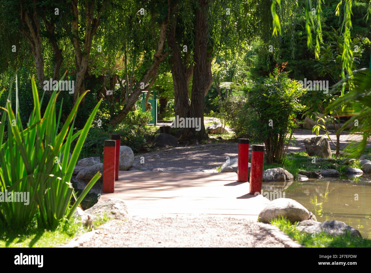 Little red bridge in a city park on a sunny day Stock Photo - Alamy