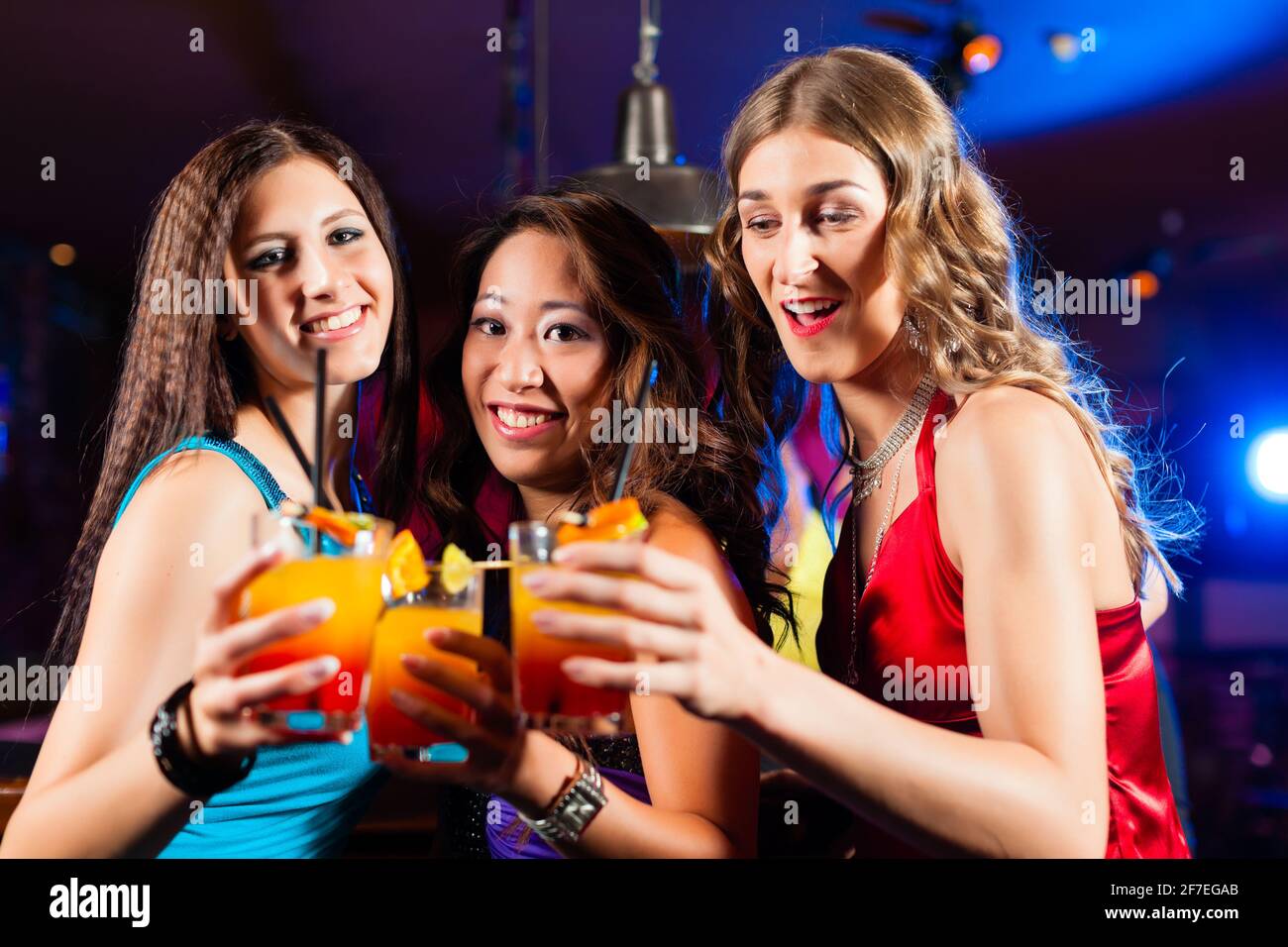 Group of party people - three female girl friends - with cocktails in a ...