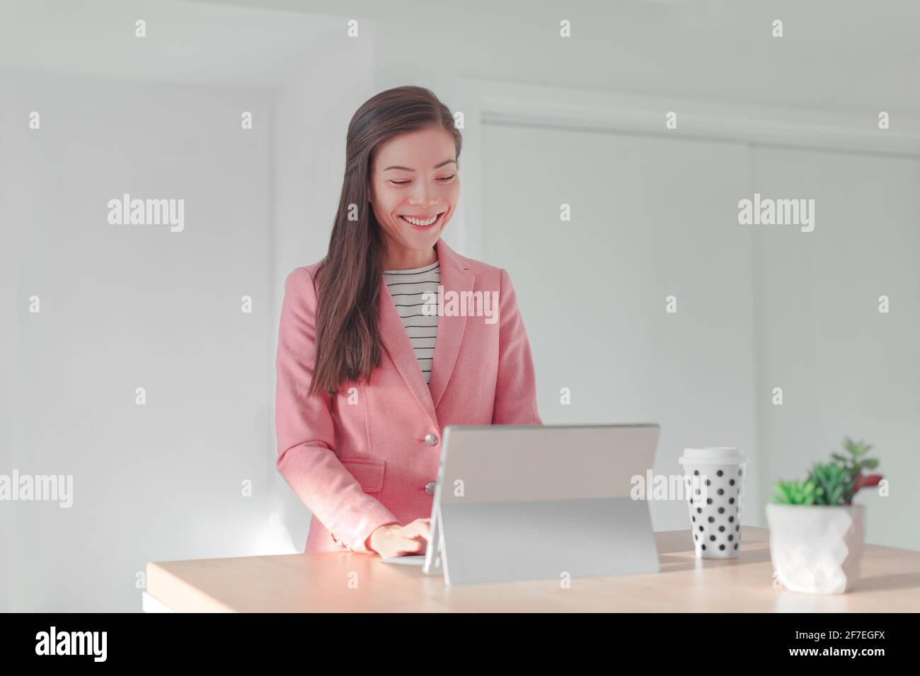Remote work Asian woman working from home on office laptop at standing ...