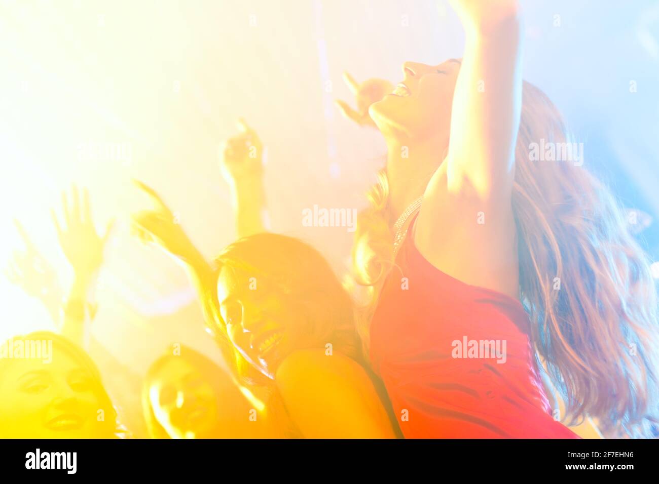Group of party people - men and women - dancing in a disco club to the ...