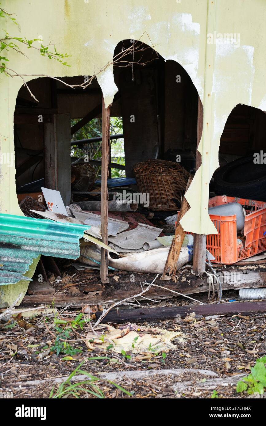 Large holes in shack walls showing accumulated rubbish inside Stock ...