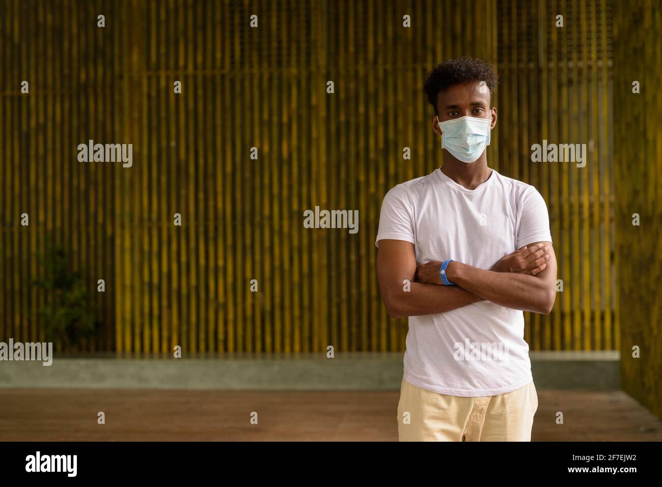 Handsome black African man with arms crossed wearing face mask Stock ...