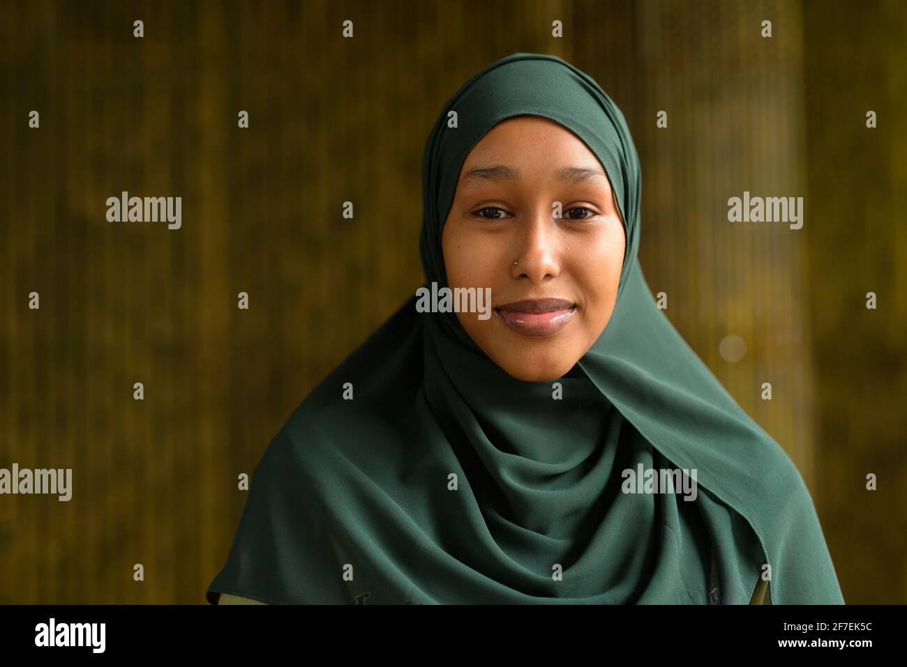 Portrait of beautiful black African Muslim woman outdoors looking at ...
