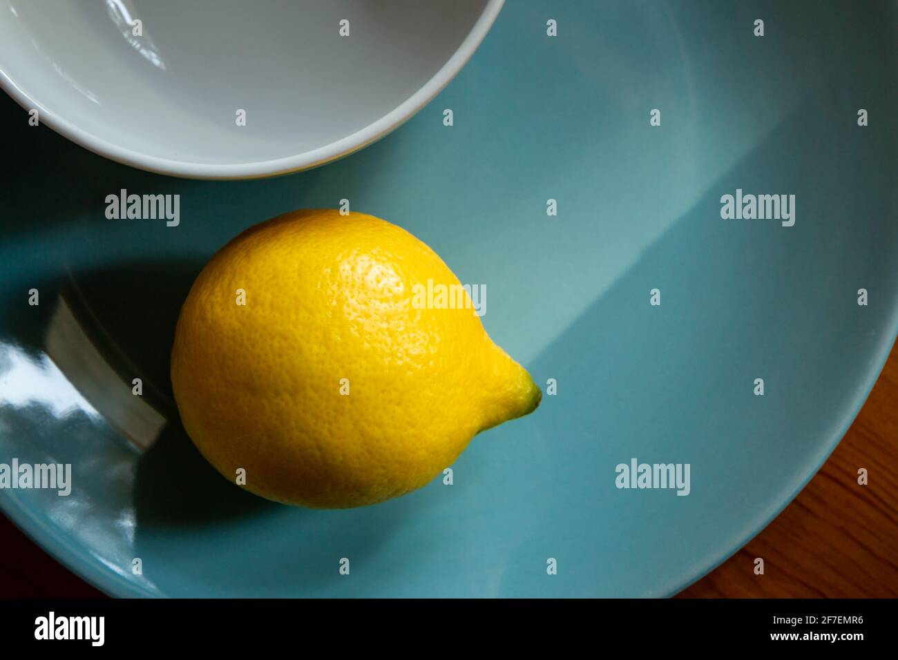 Yellow lemon on the blue plate Stock Photo - Alamy