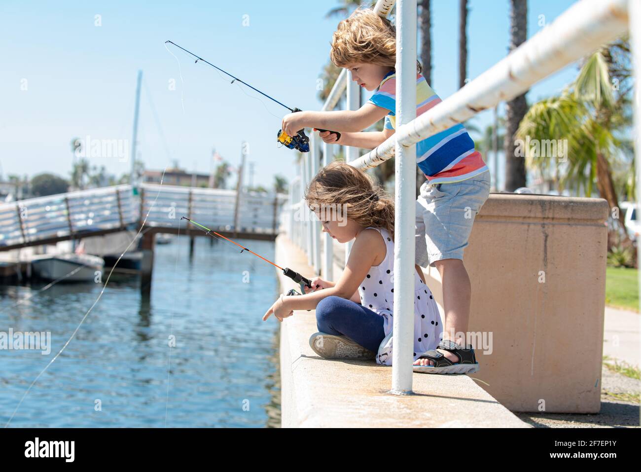 Couple of kids fishing on pier. Child at jetty with rod. Boy and girl ...