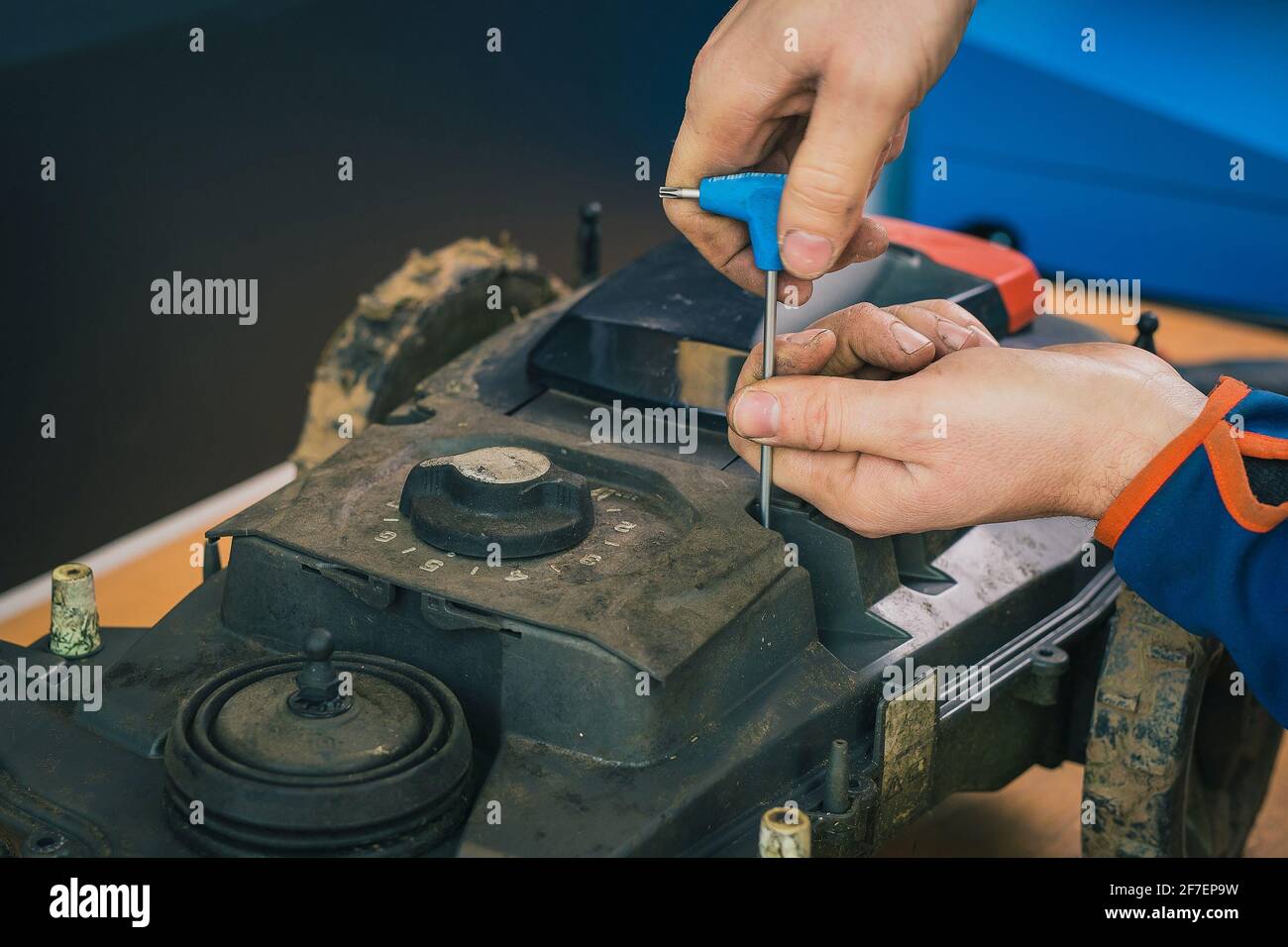 Serviceman stripping robotic lawnmower with imbus tool, motorized ...