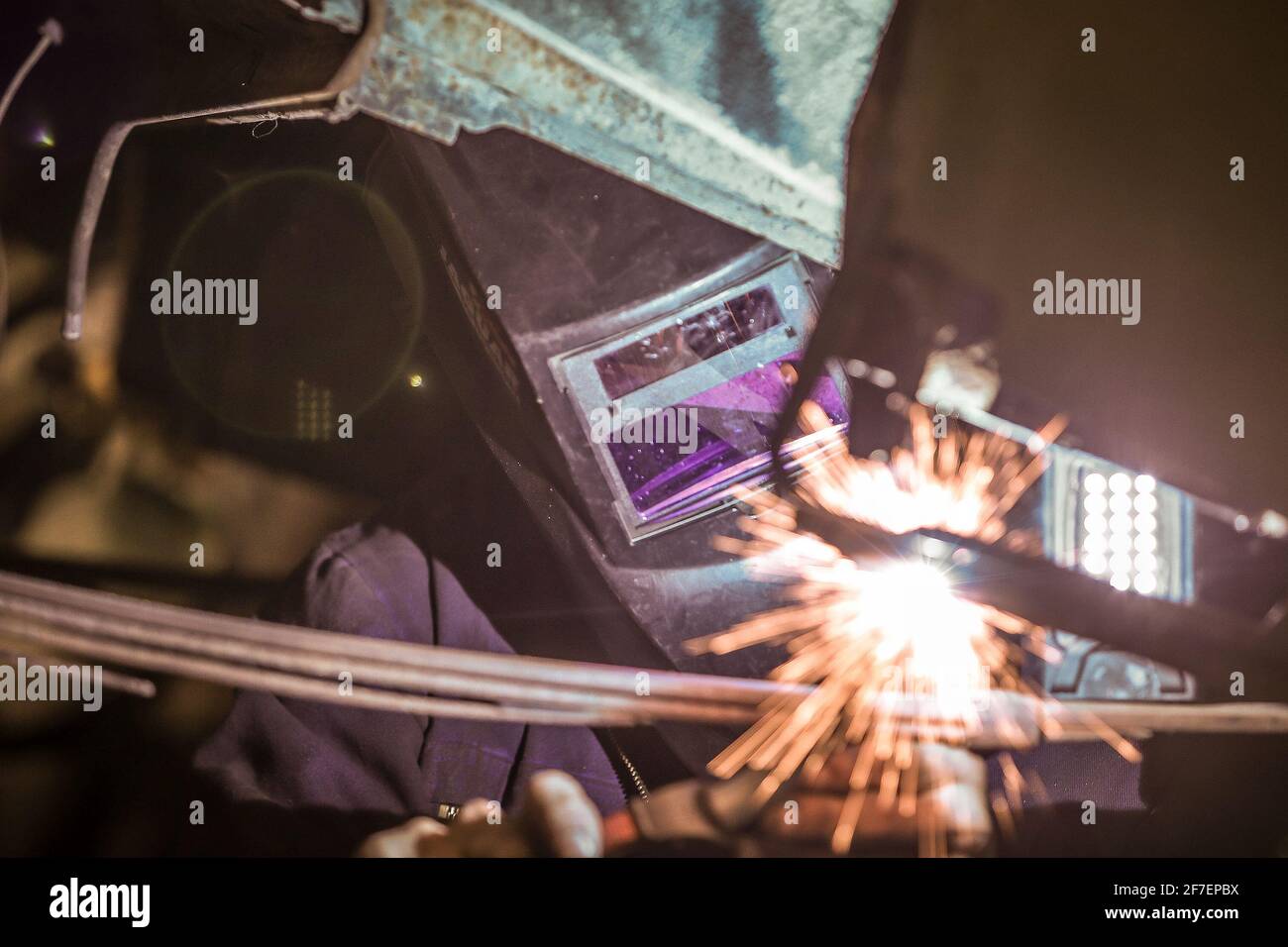 A person welding a part of a vintage car with a plan to restore it ...