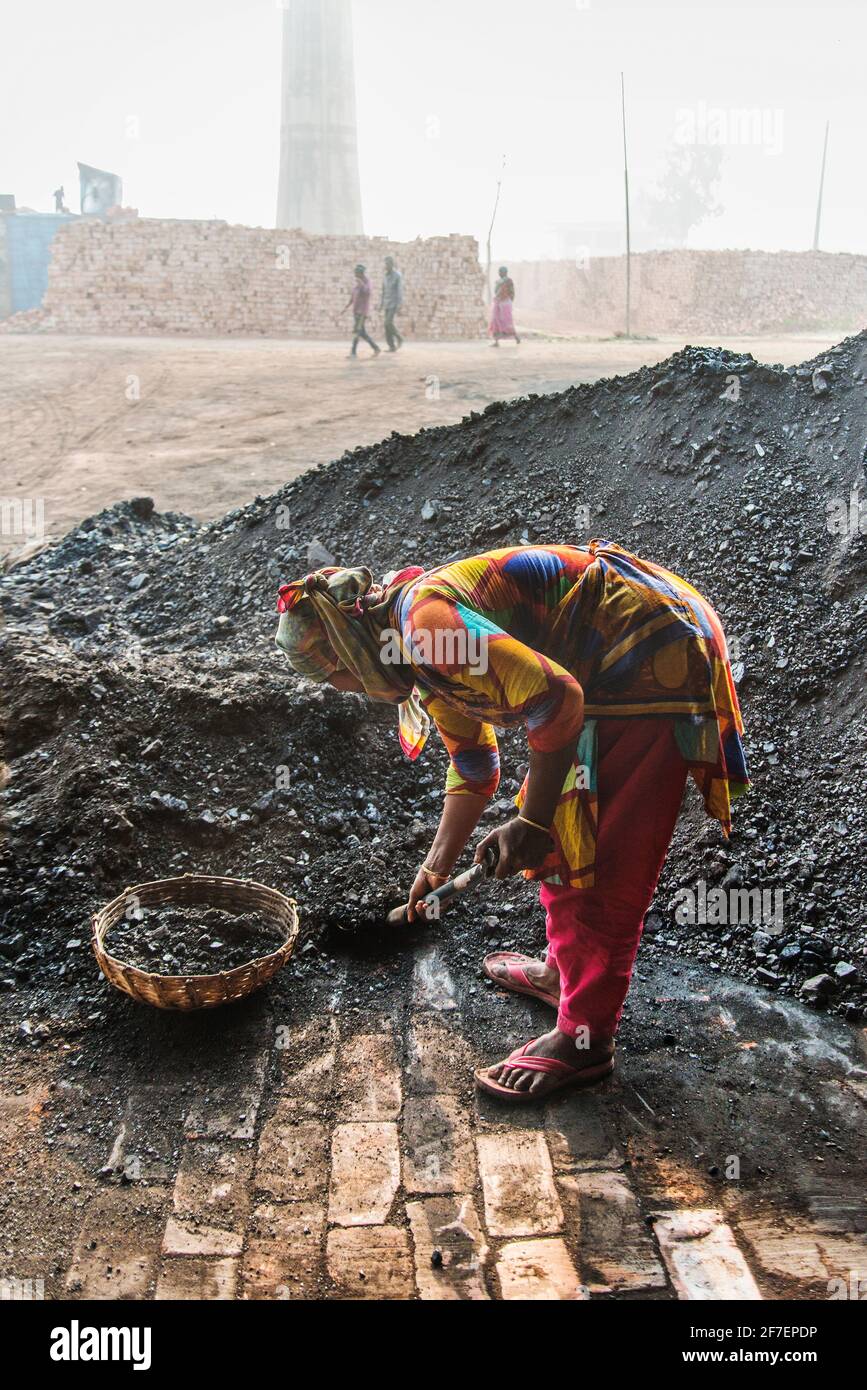 A female labour works on coal at a brickfield at Khulna, Bangladesh ...