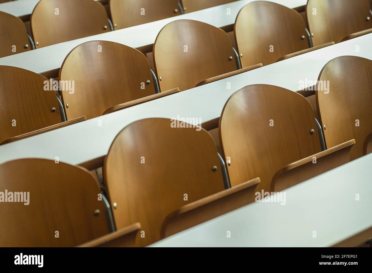 Detail of a multitude of rows of wooden seats in a classroom or in ...
