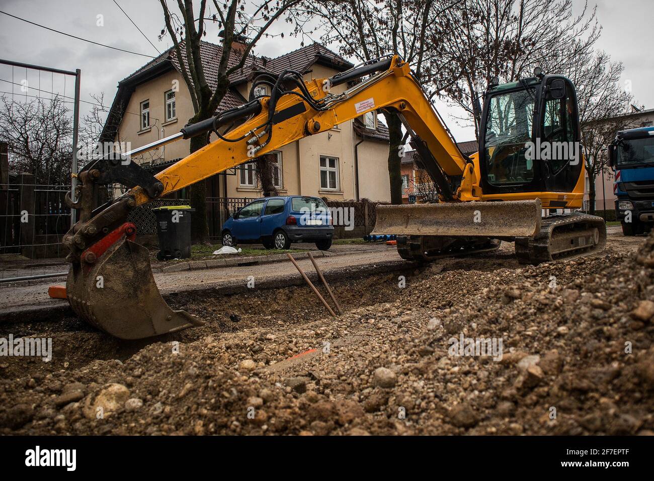 Construction site on a city street. A yellow digger excavator parked ...