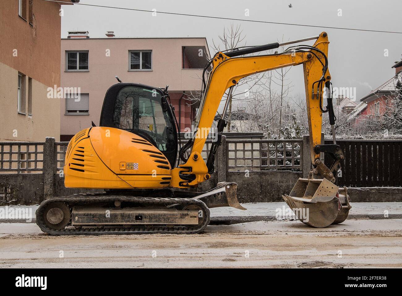 Construction site on a city street. A yellow digger excavator parked on ...