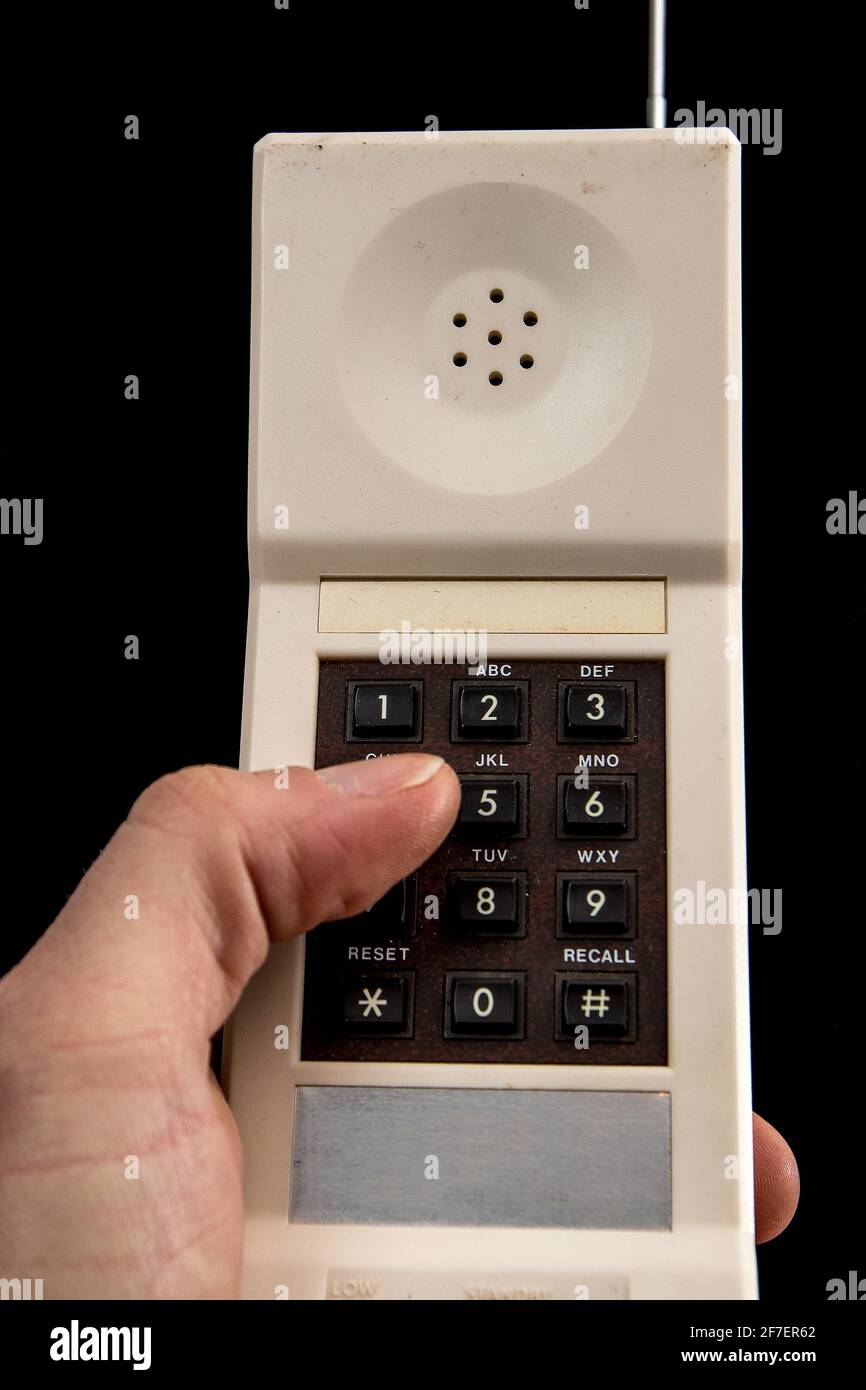 An old white vintage cordless telephone from the eighties isolated on ...