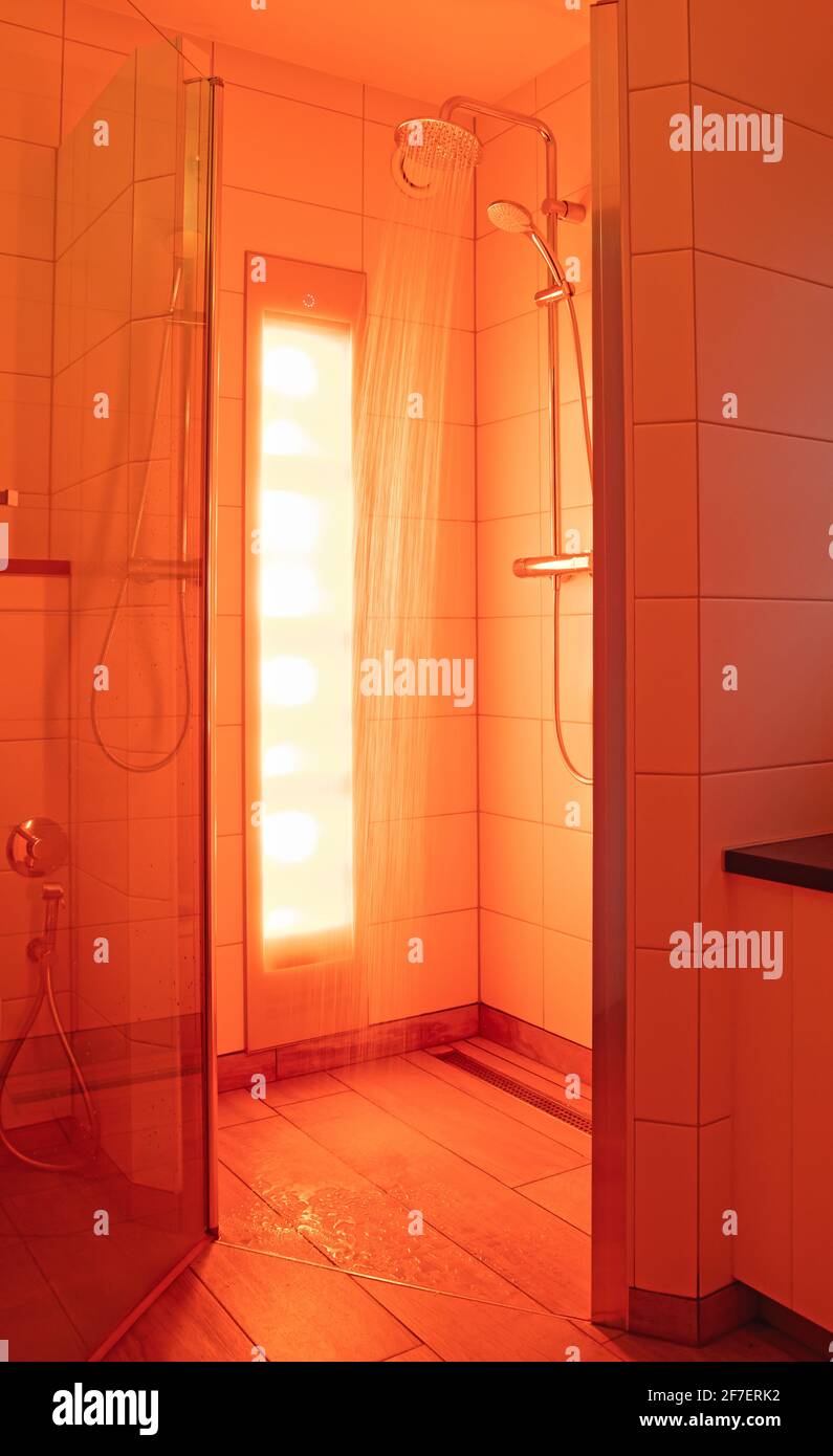Luxury sunshower in a bathroom, lights glowing while water is flowing ...