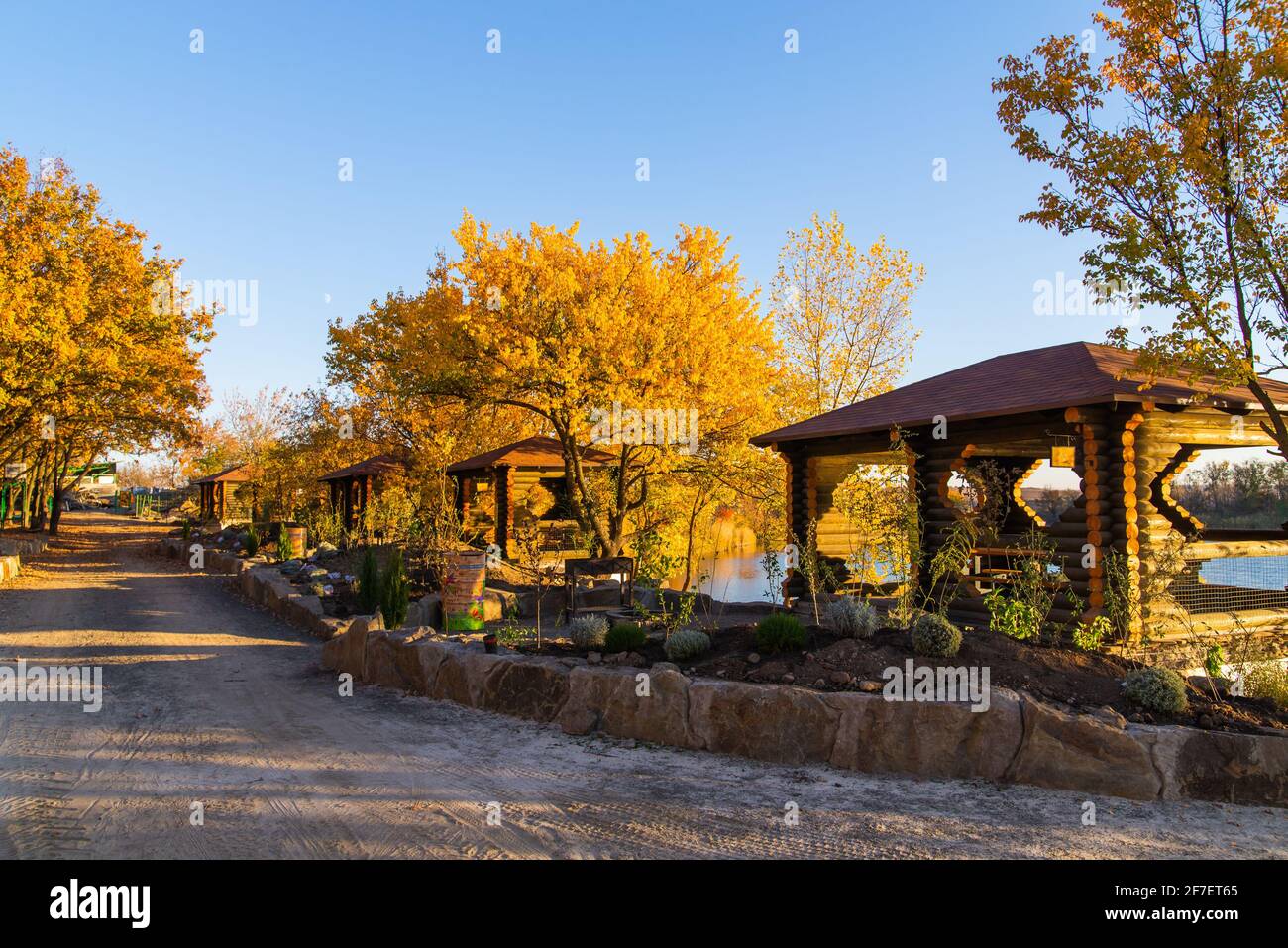 Autumn view of riverside park with wooden houses and benches Stock ...