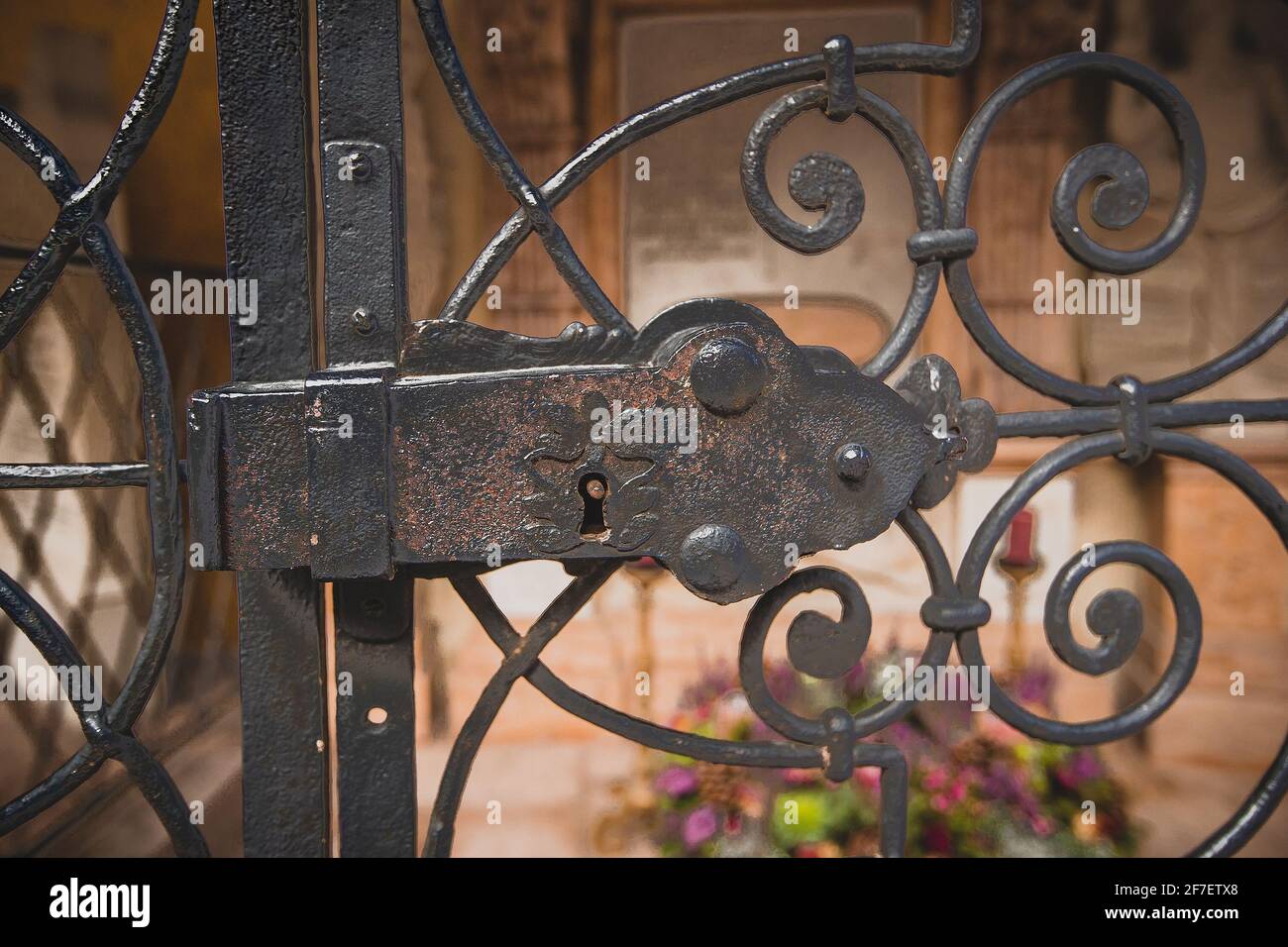 Metal vintage lock as a part of a door in front of an old grrave or a ...