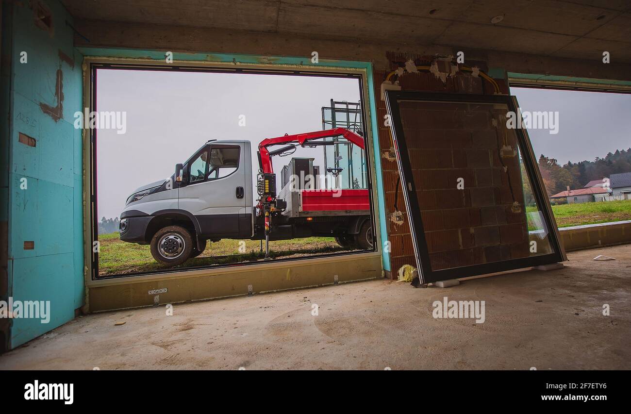 A truck with hydraulic arm and loaded with glass windows is waiting ...