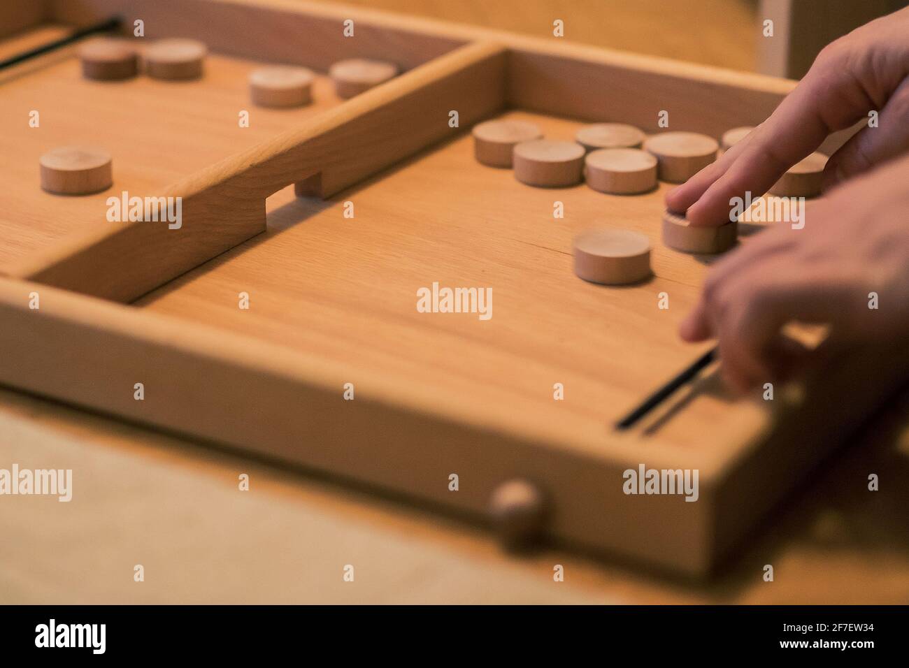 Wooden bard game where you shoot round wooden blocks through opening ...
