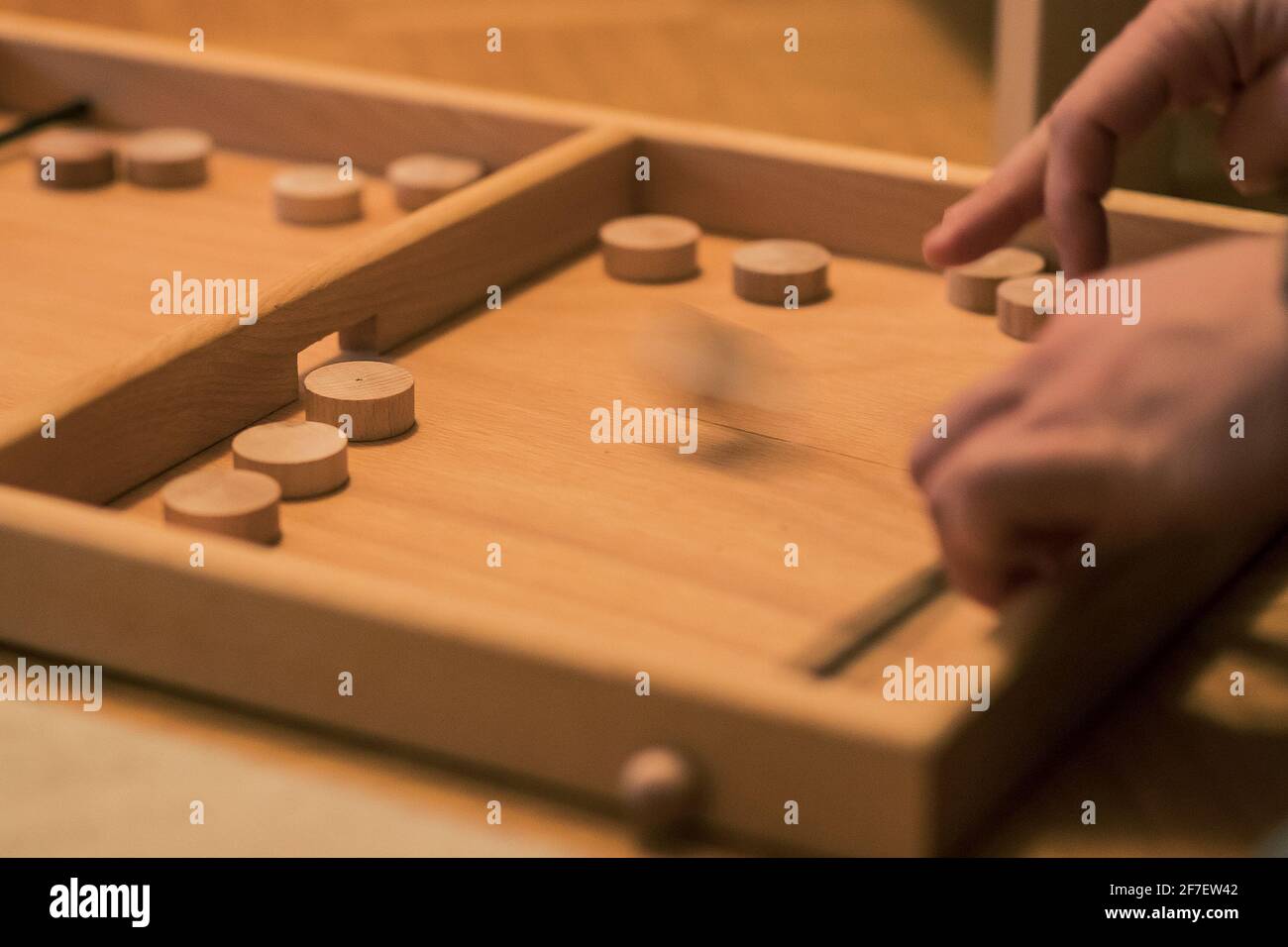 Wooden bard game where you shoot round wooden blocks through opening ...