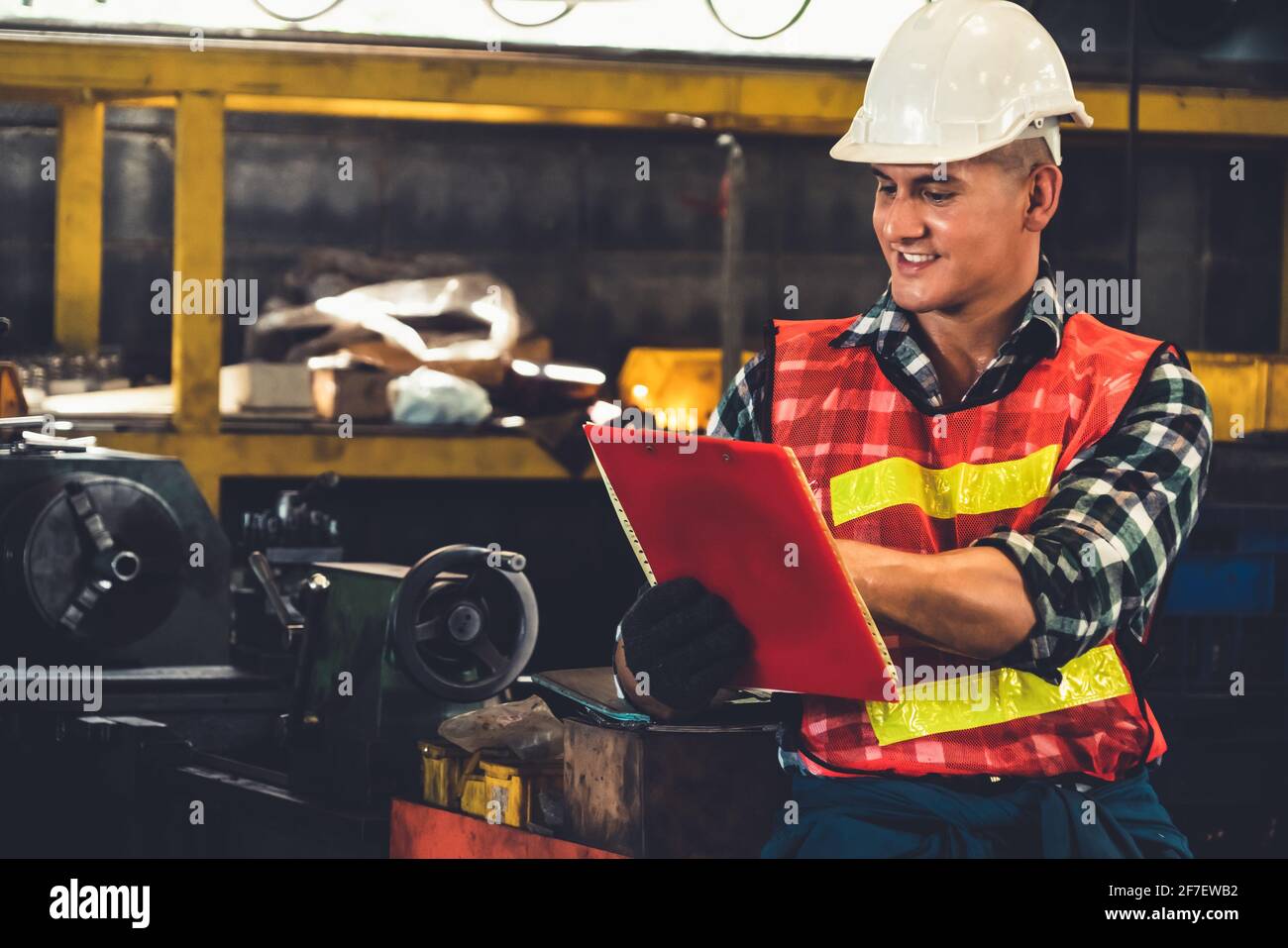 Manufacturing worker working with clipboard to do job procedure ...