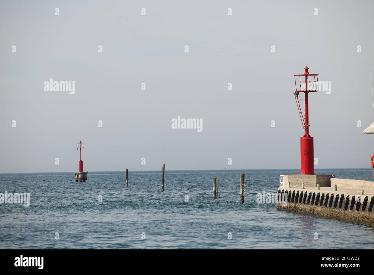 Two red safety light beacons on the sea. Small lighthouses on the ...