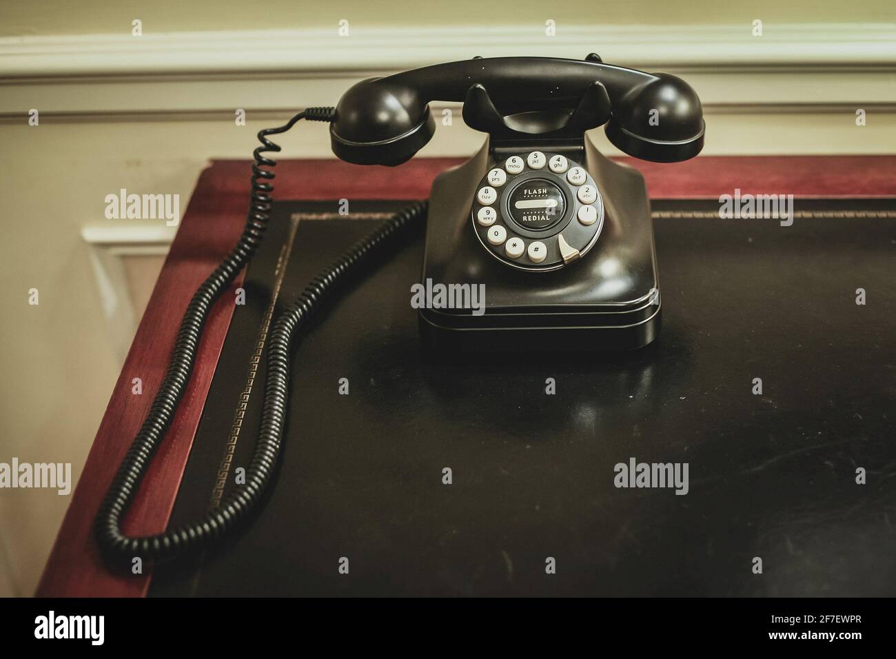 An old vintage phone sitting on an office desk. A rotary dial oldtimer ...