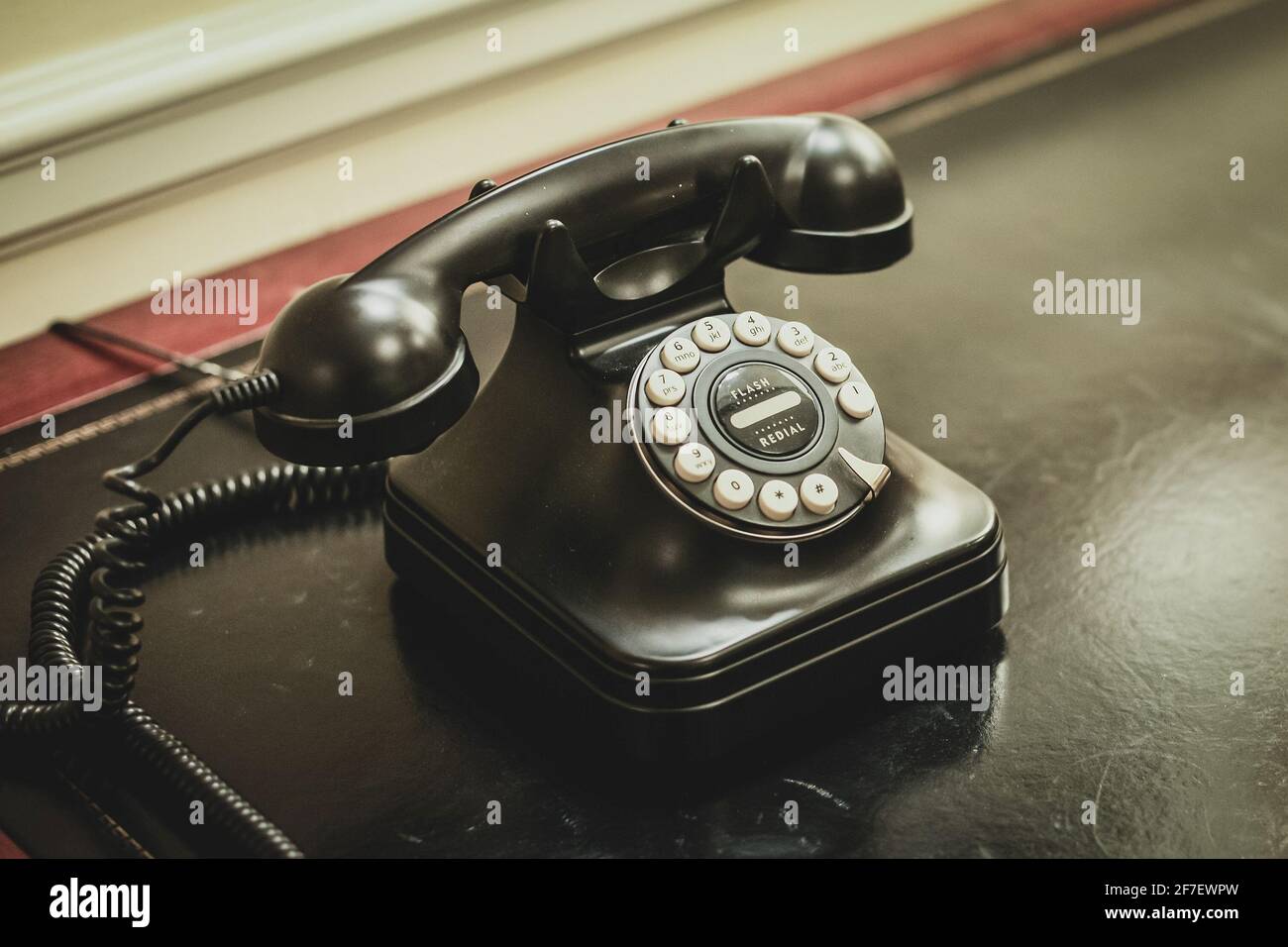 An old vintage phone sitting on an office desk. A rotary dial oldtimer ...