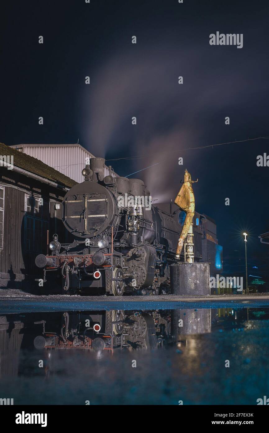 Old steam locomotive being fired up in front of a turntable during the ...