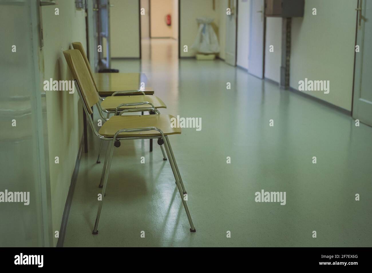 Waiting place in an old hallway of a hospital. Wooden and metal chairs ...